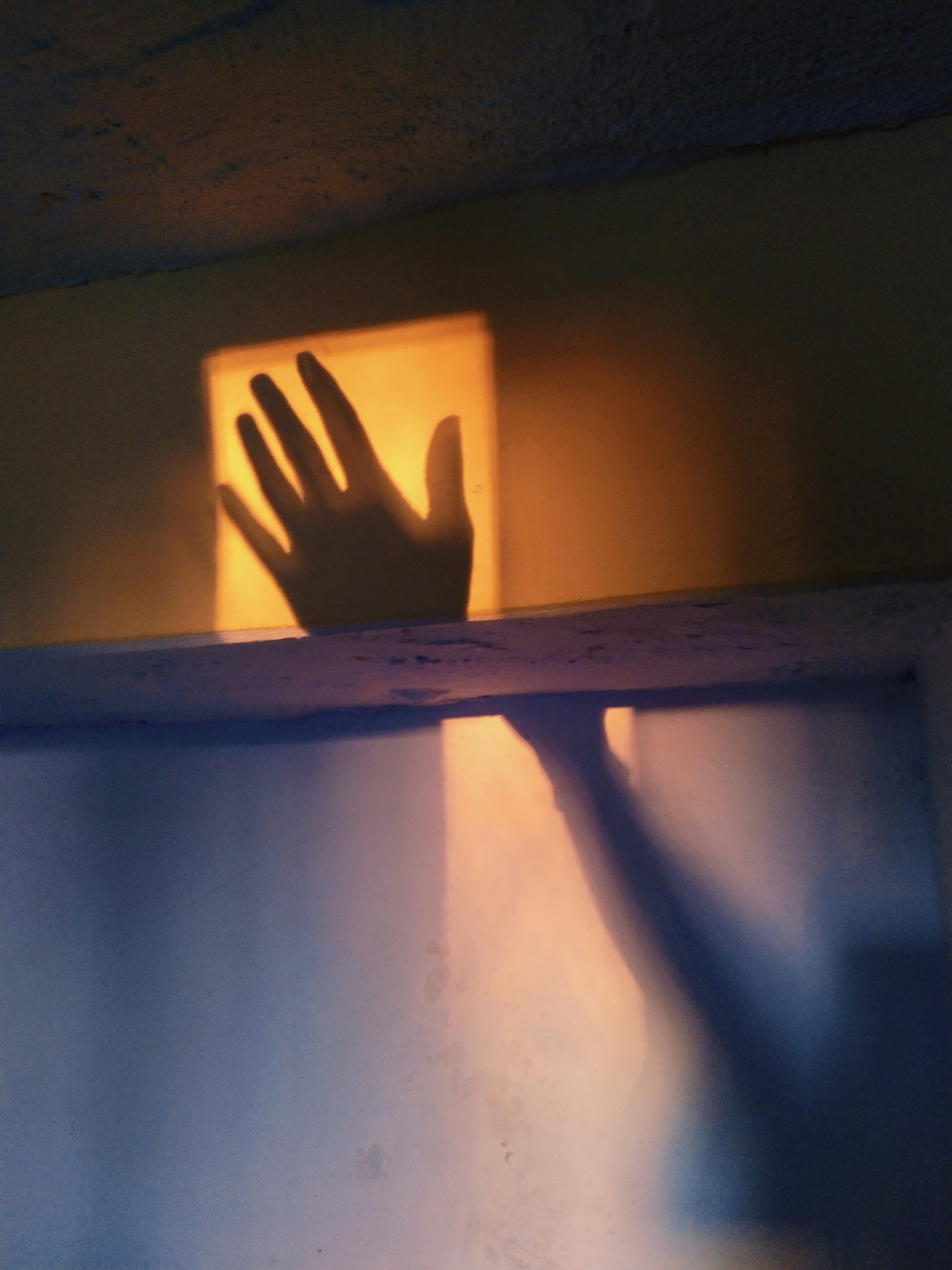 Shadow of a hand reaching towards light