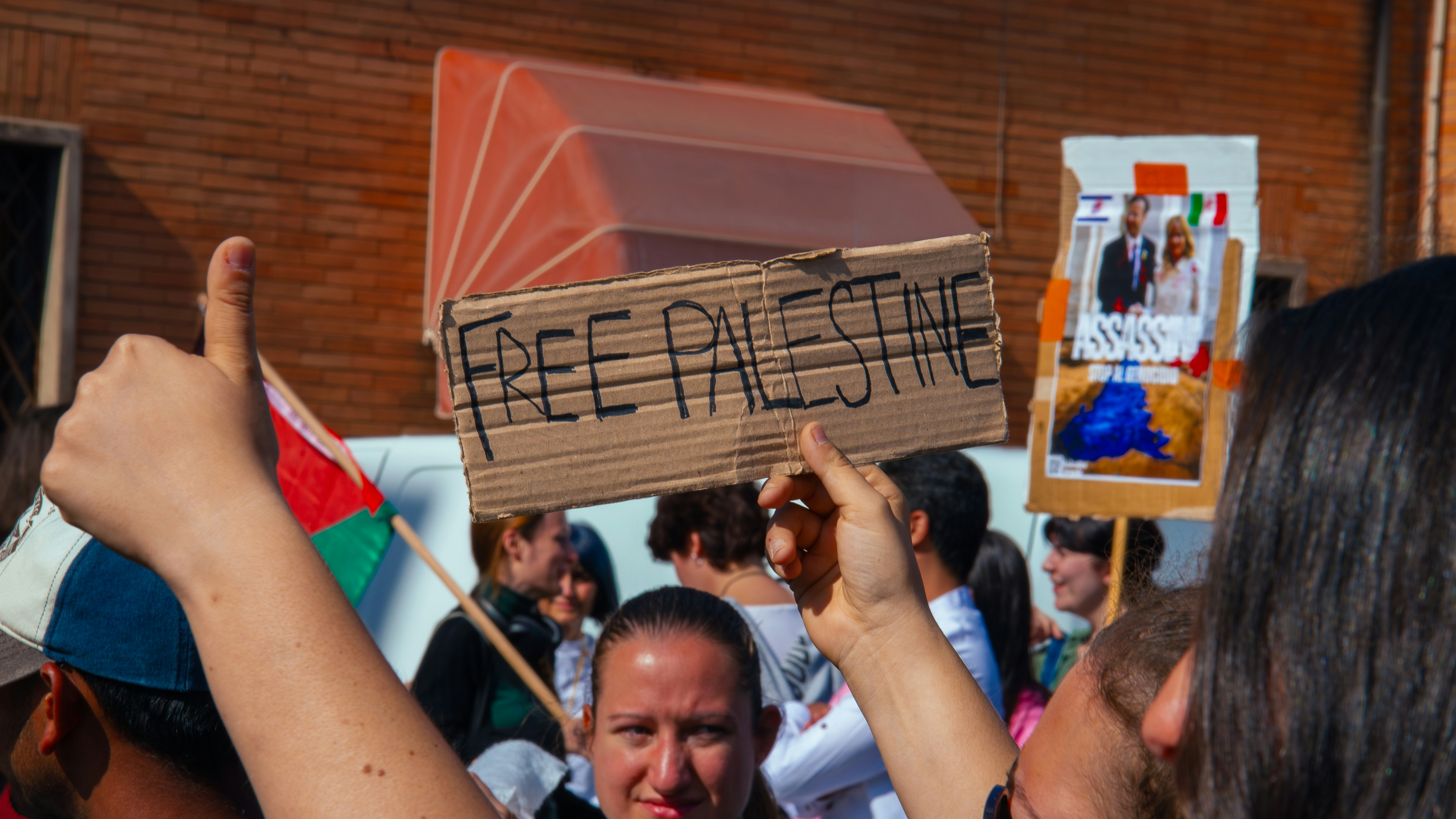 Palestine | Protesters hold signs at a rally for free palestine.