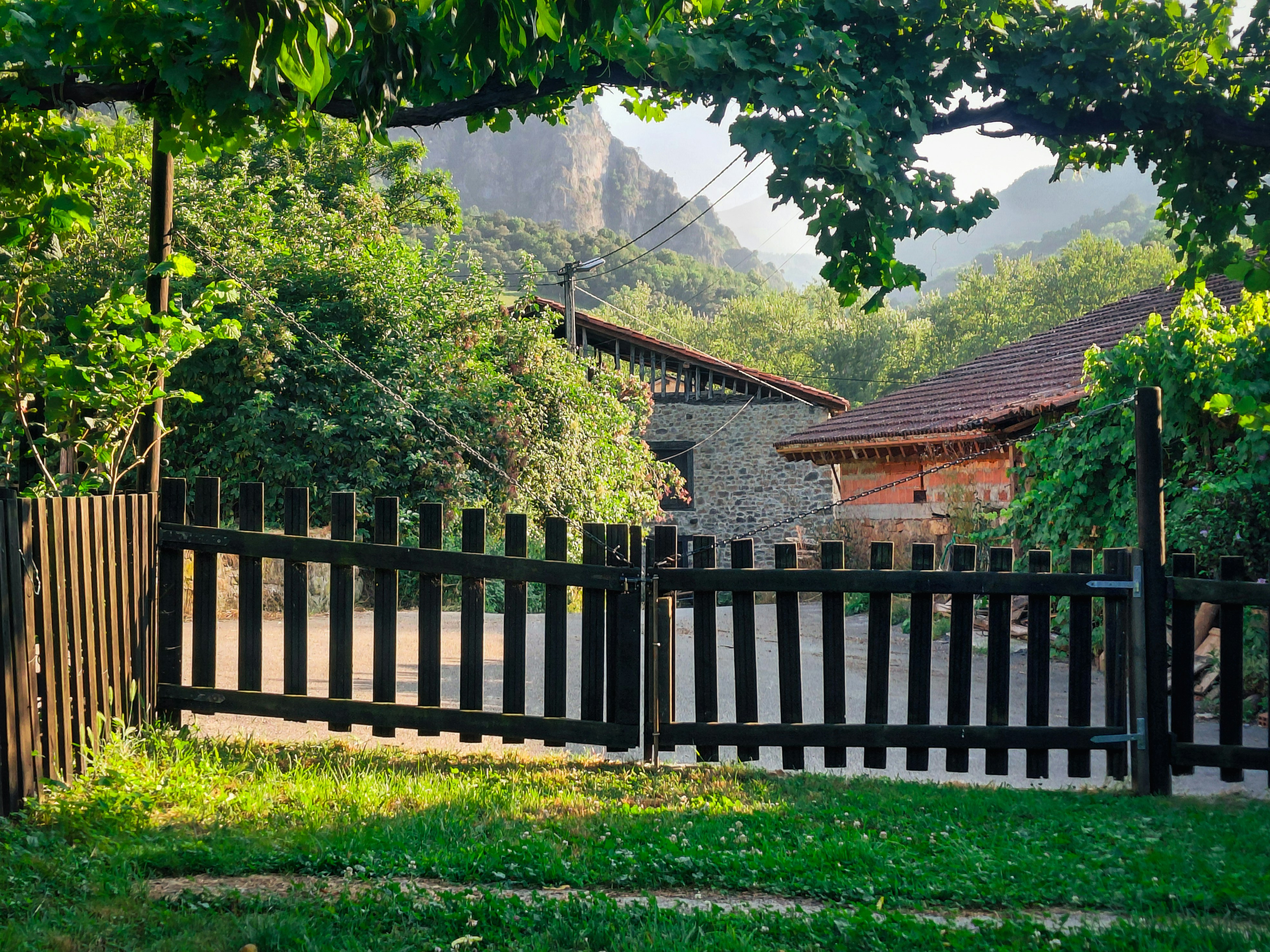 Wooden fence guards entrance to rural village homes.