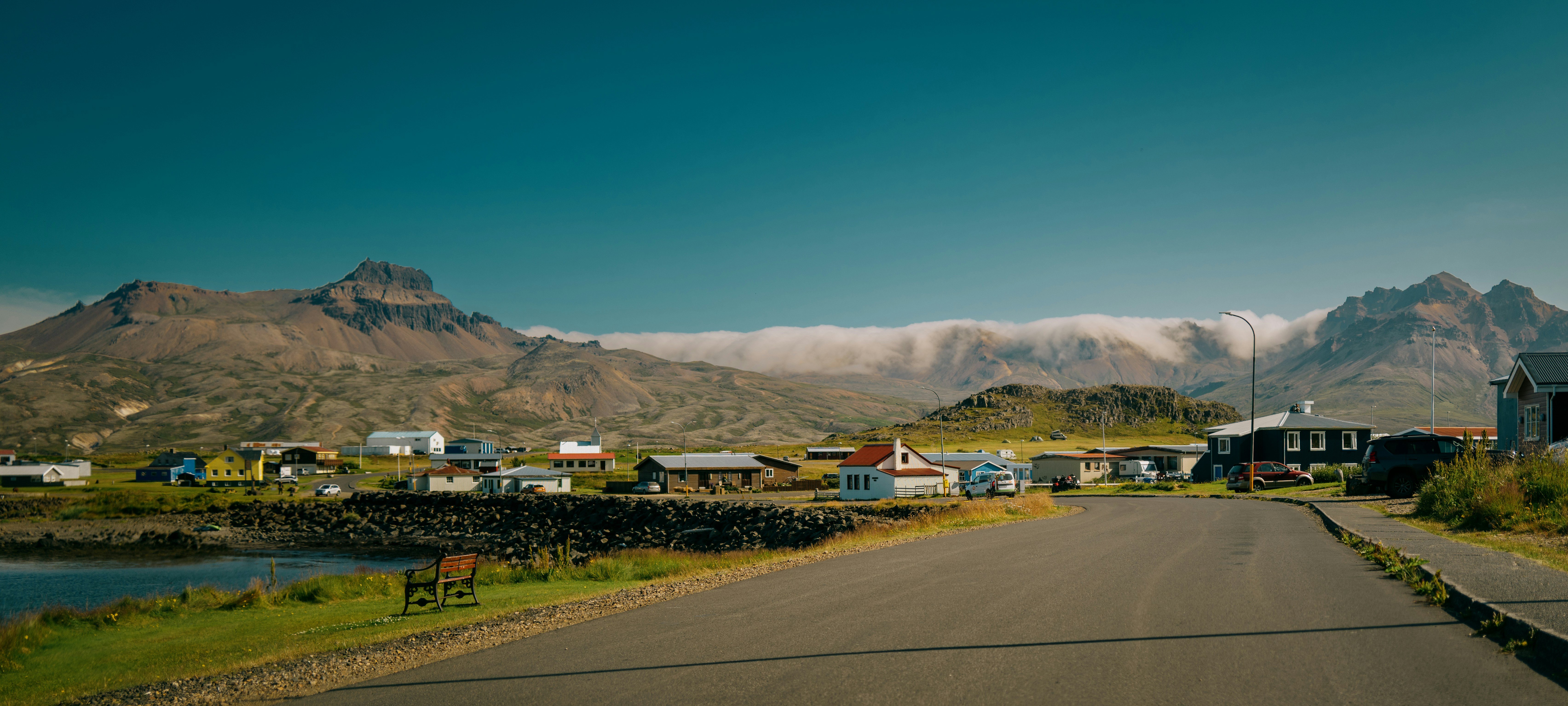 Pastel Harbor Lane Under Rugged Peaks