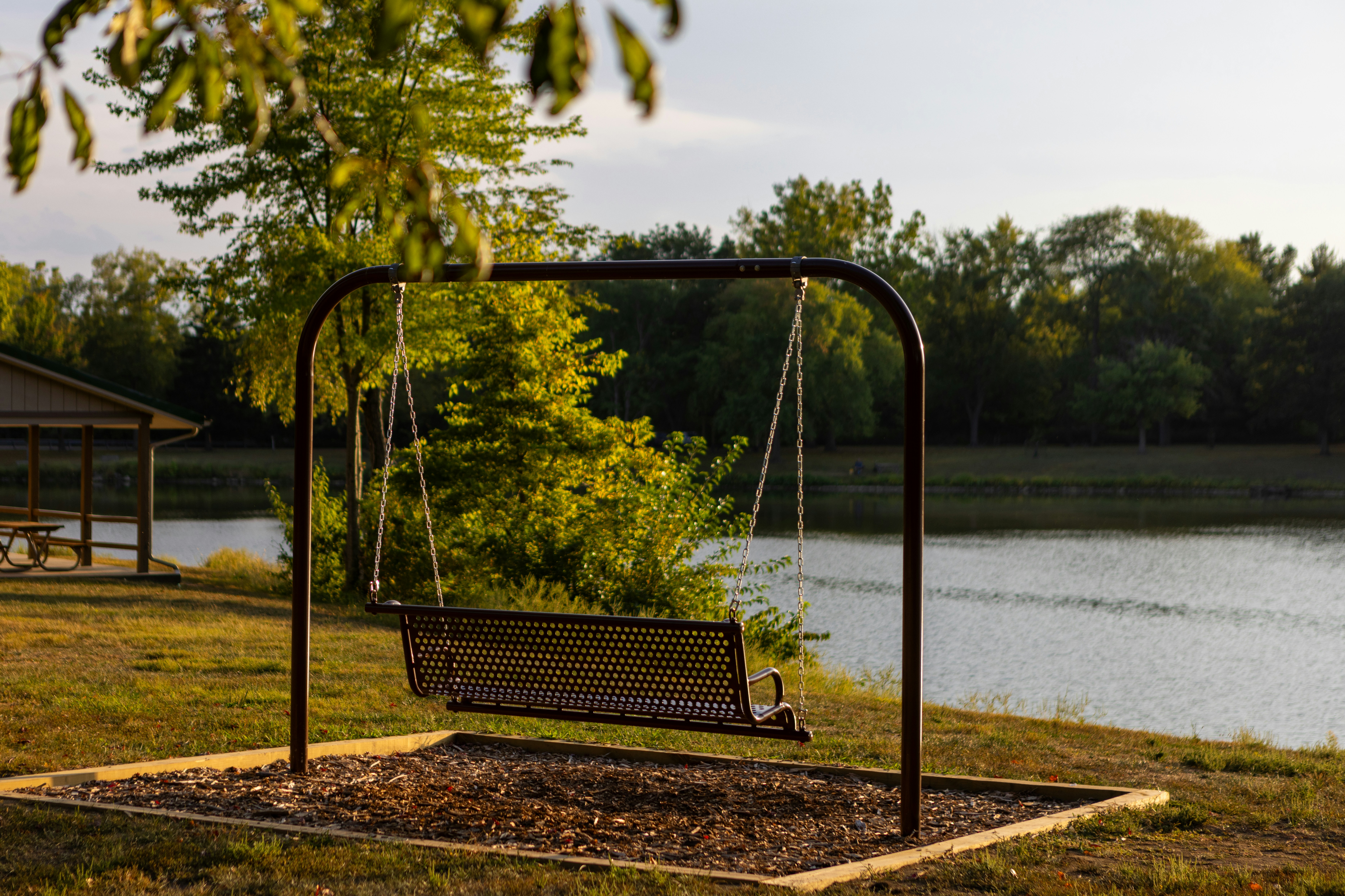 Empty swing set by a calm lake