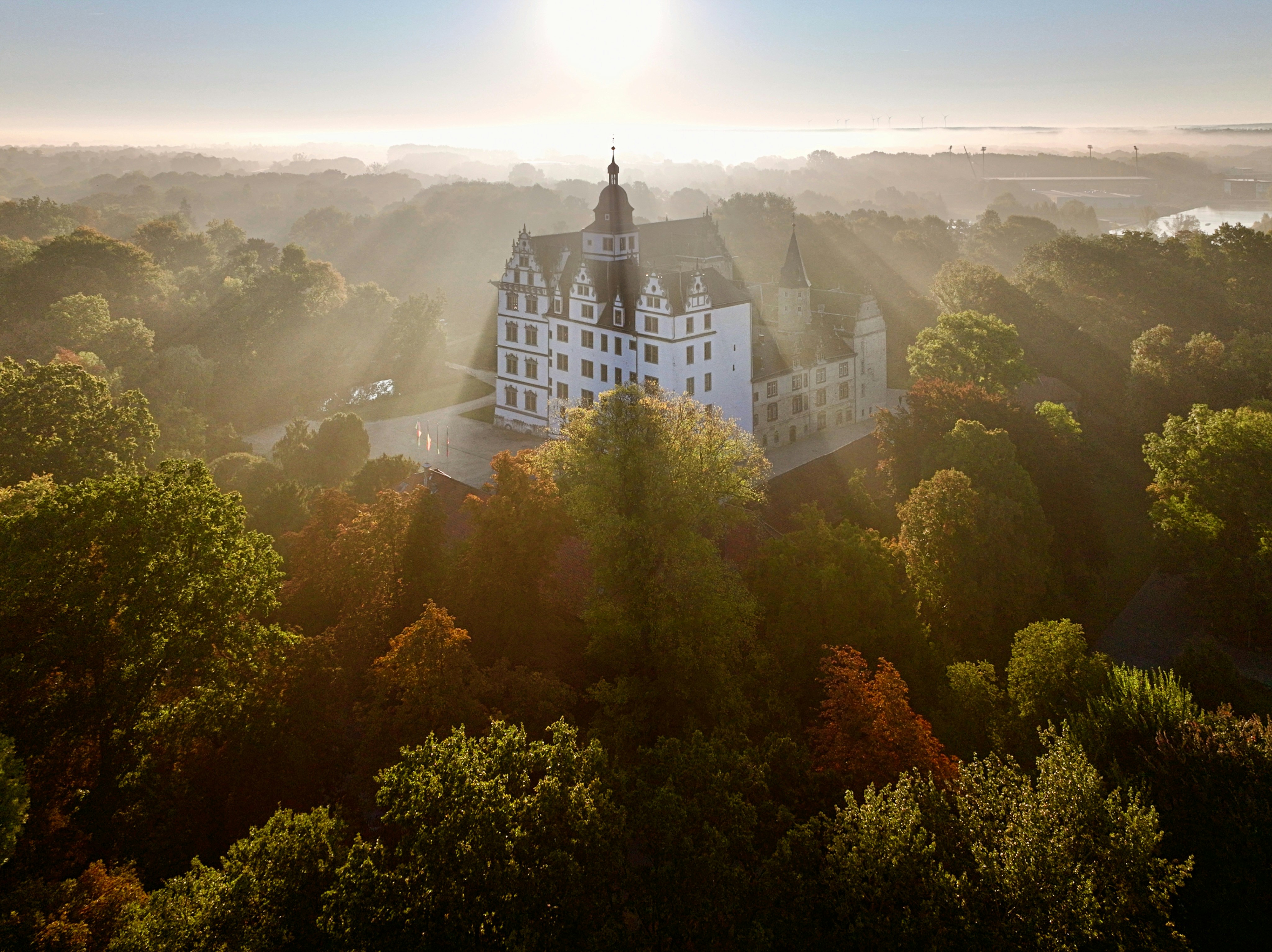 Castel in sunrise | White castle surrounded by trees at sunrise