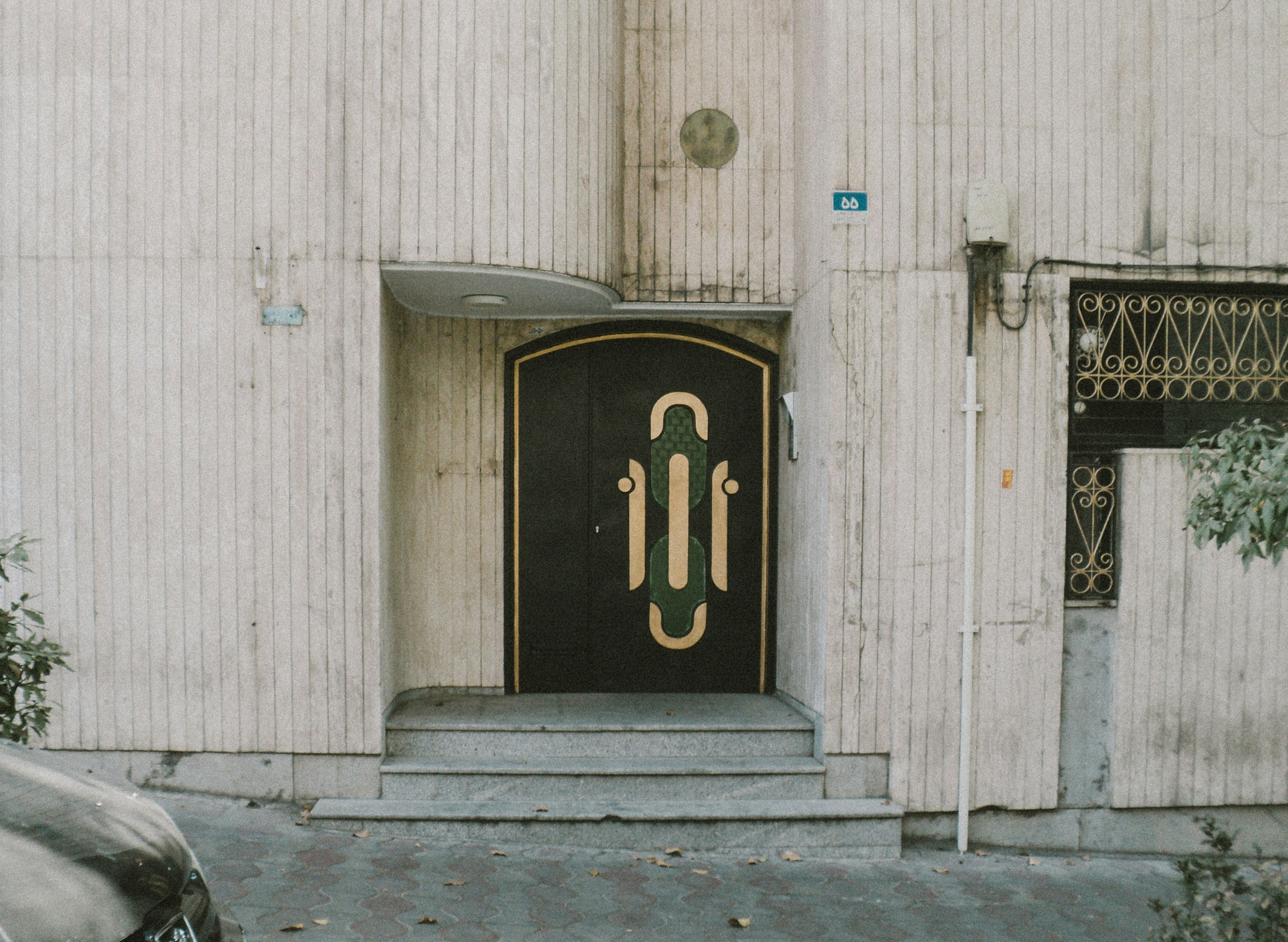 A doorway to another time. | Ornate black door with gold accents on building.