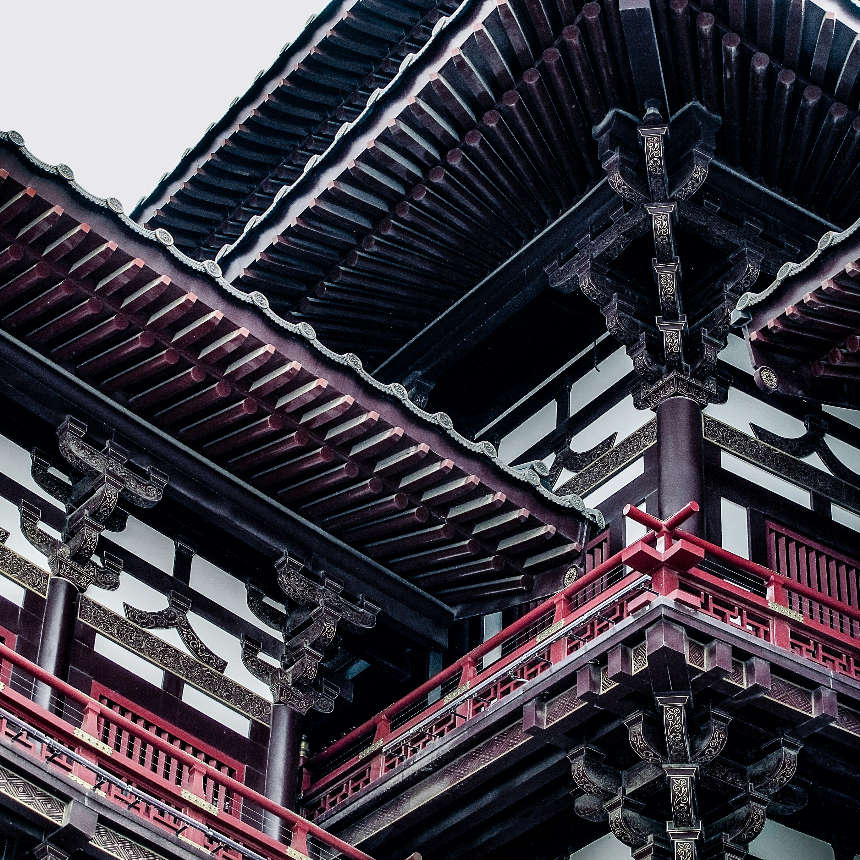 Intricate wooden architecture showcasing traditional design elements with vibrant red accents and detailed carvings.