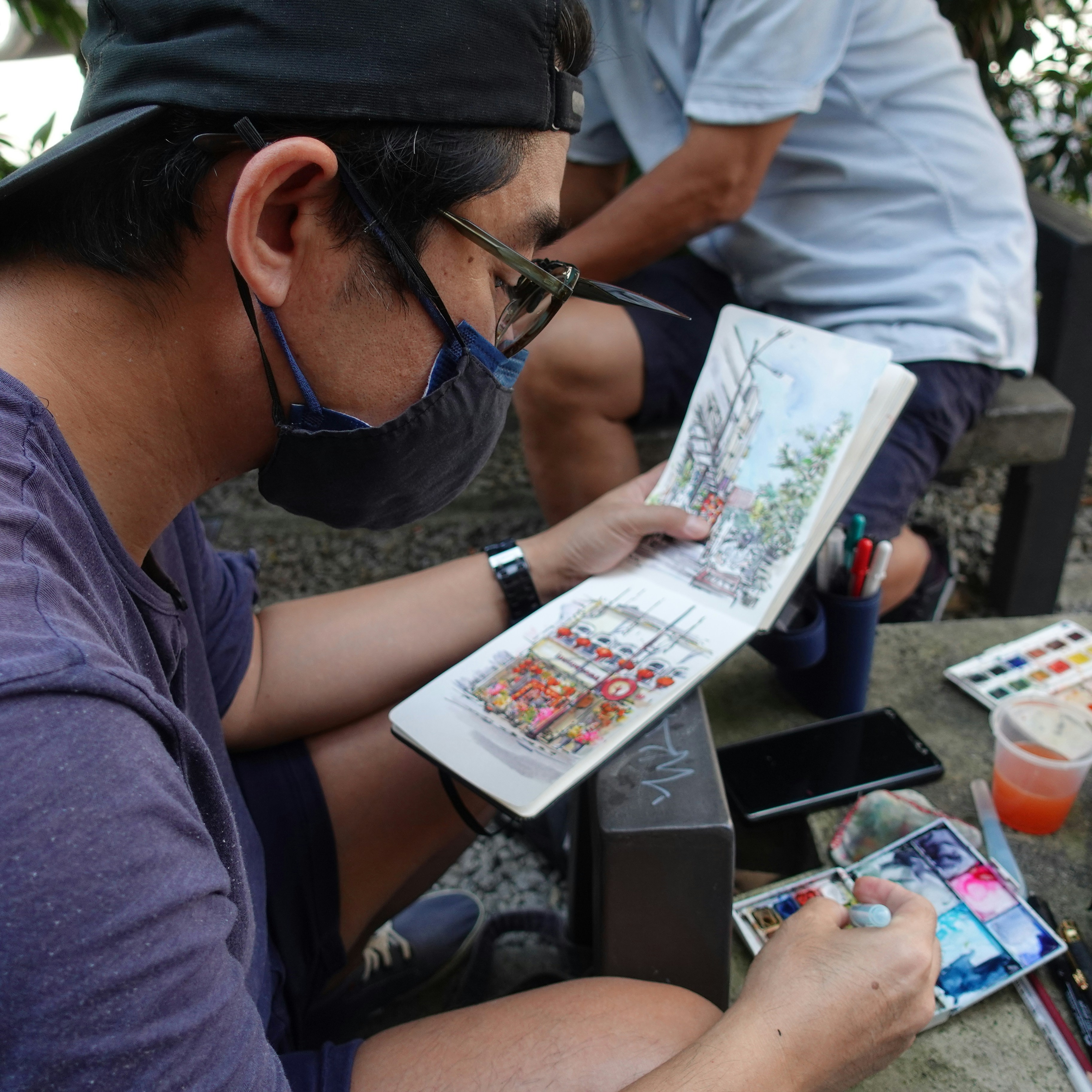 water colour artist at work with Chinese new year theme | Man sketching in a notebook with watercolors