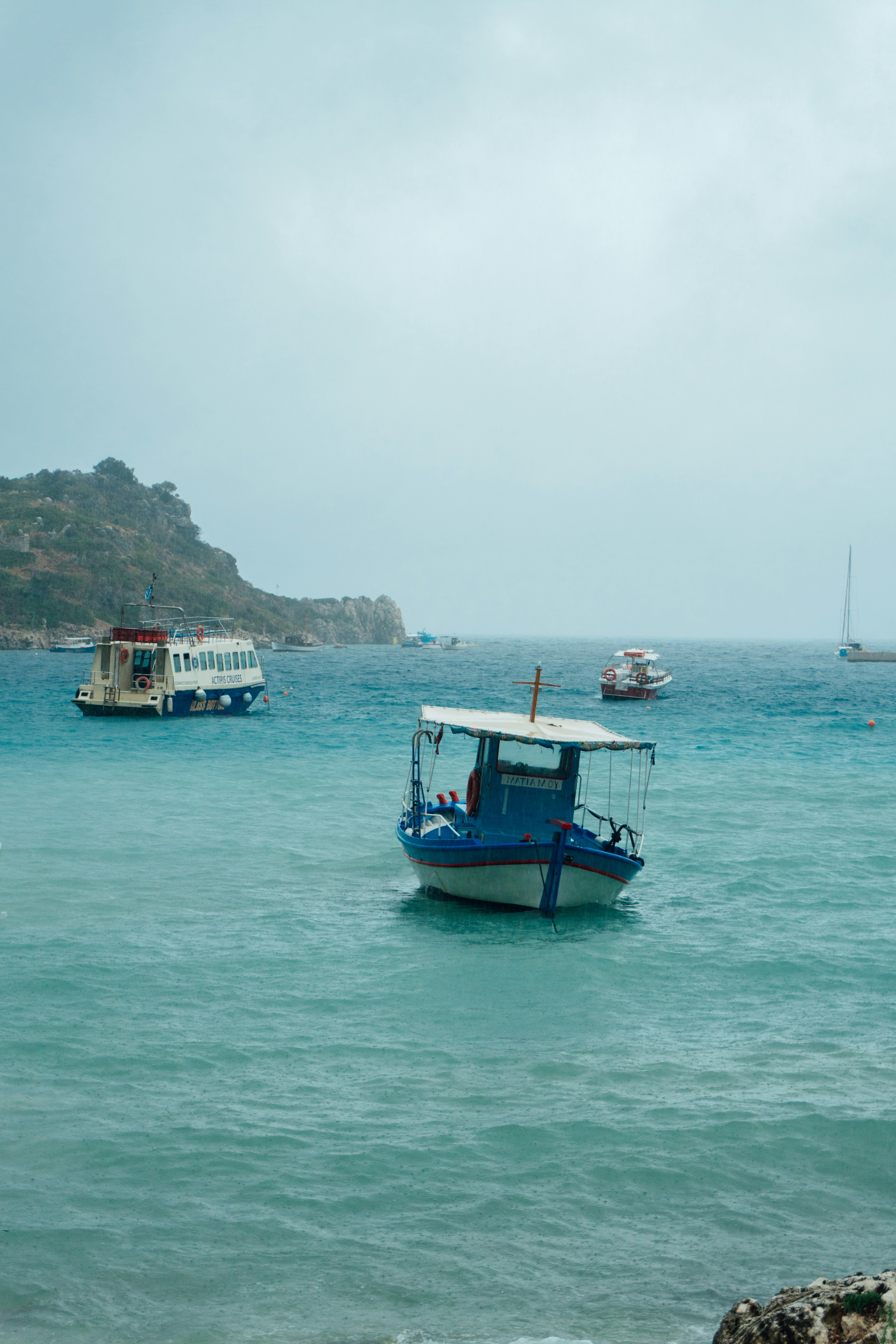 Fishing boats anchored in a tranquil bay under a cloudy sky, evoking a sense of calm and contemplation.