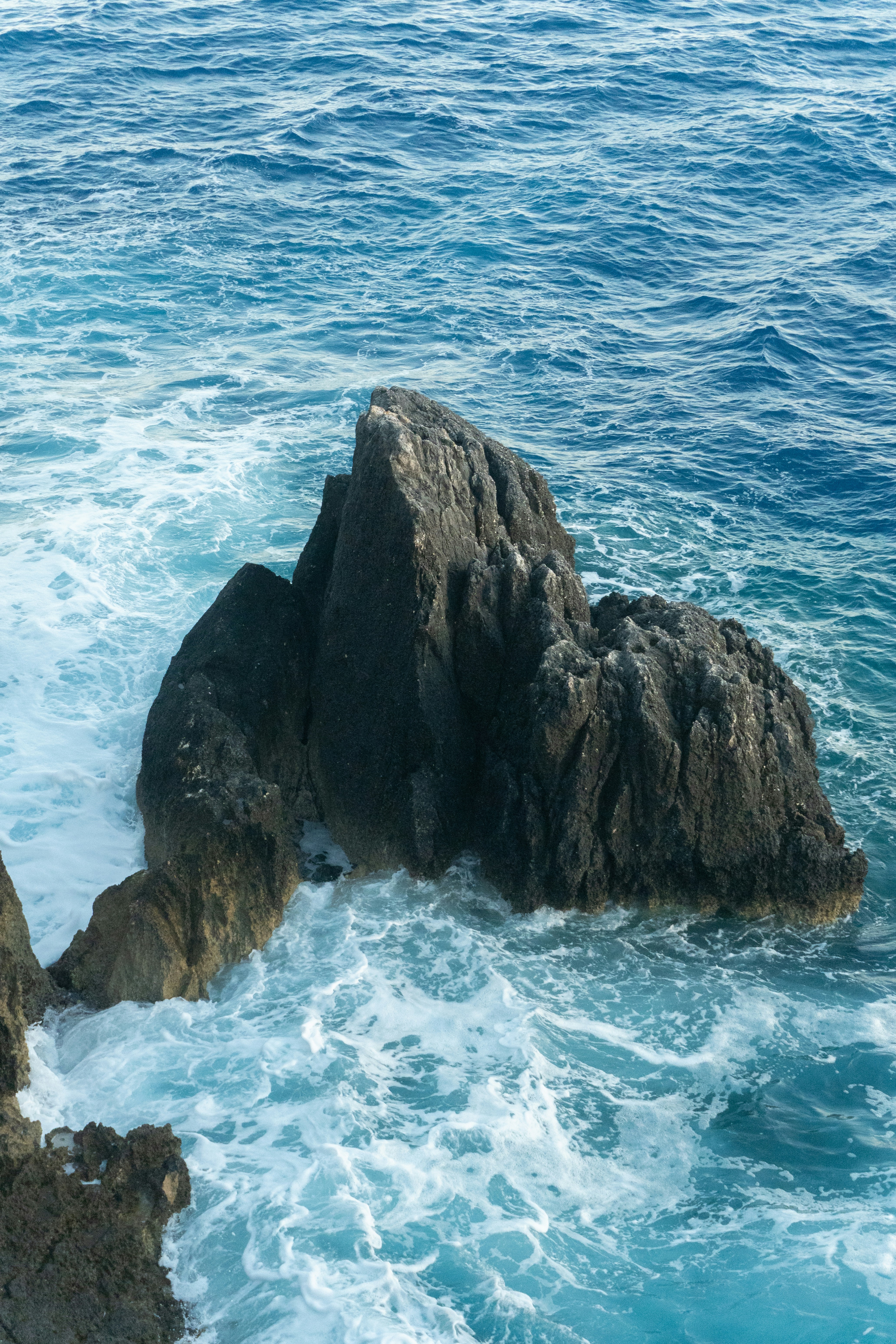 Jagged rocks in the ocean with crashing waves