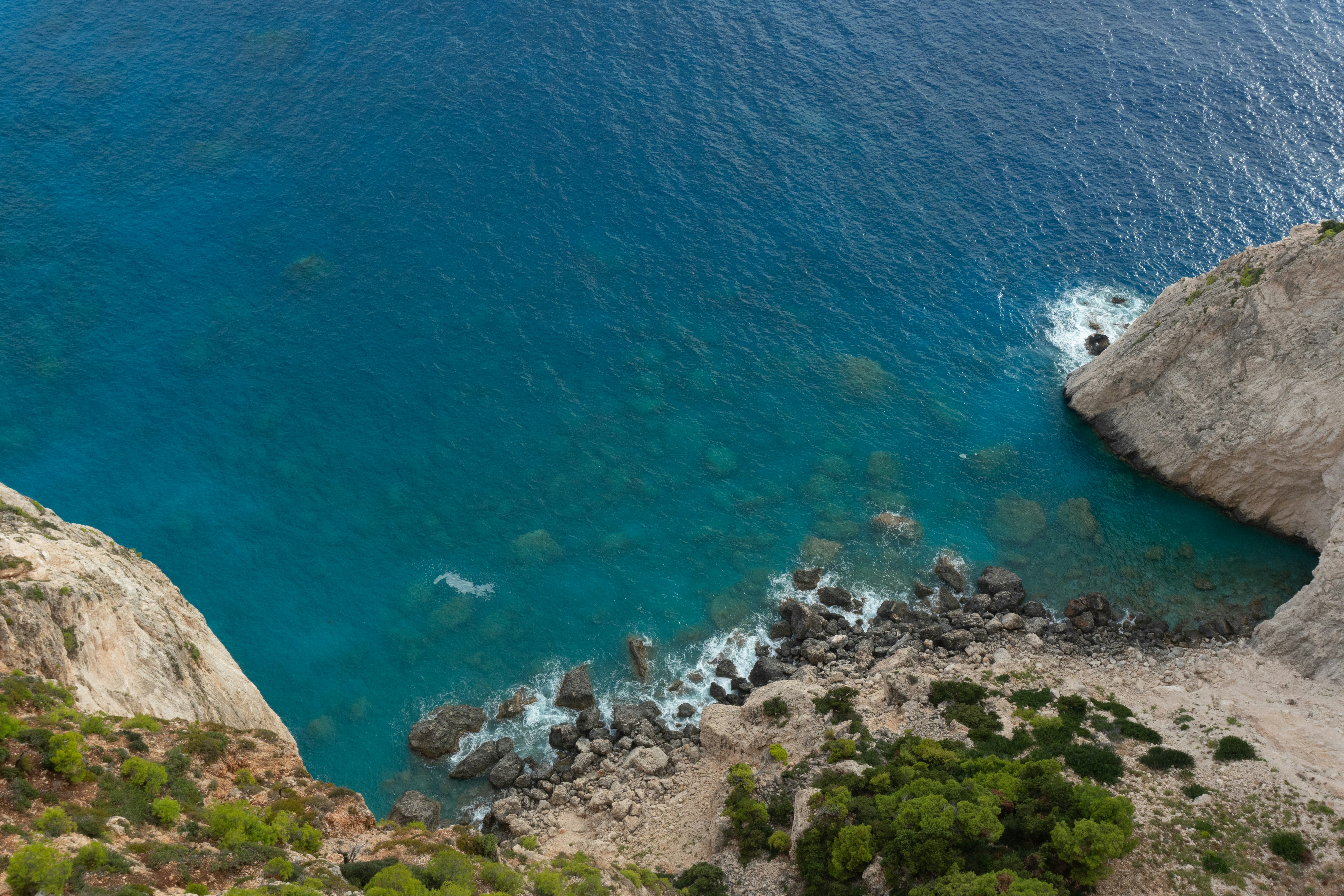 Vibrant turquoise waters gently lapping against rugged cliffs and rocky outcrops, showcasing the beauty of coastal landscapes.