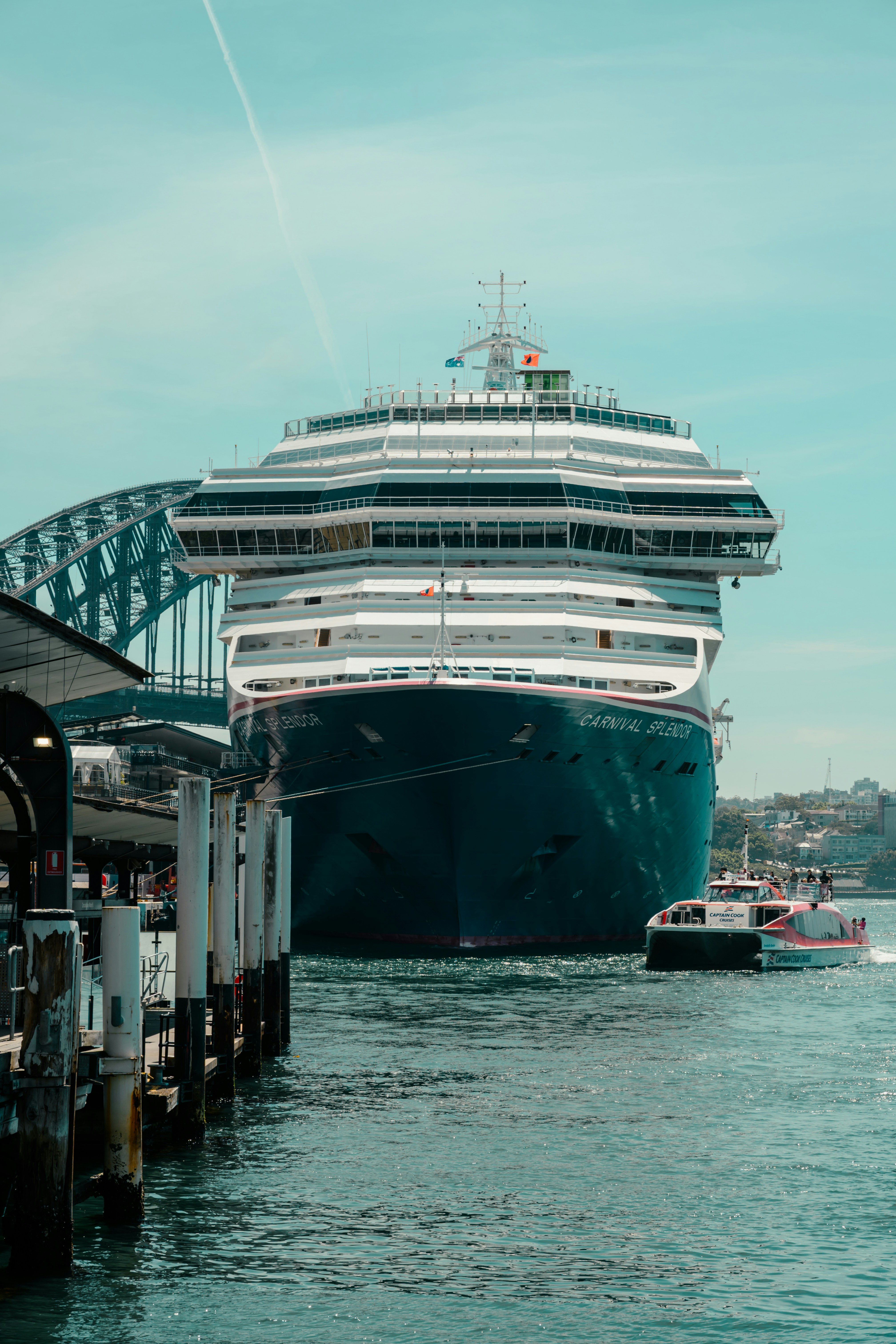 Carnival Splendor cruise ship docked at a busy harbor, with the Sydney Harbour Bridge in the background.