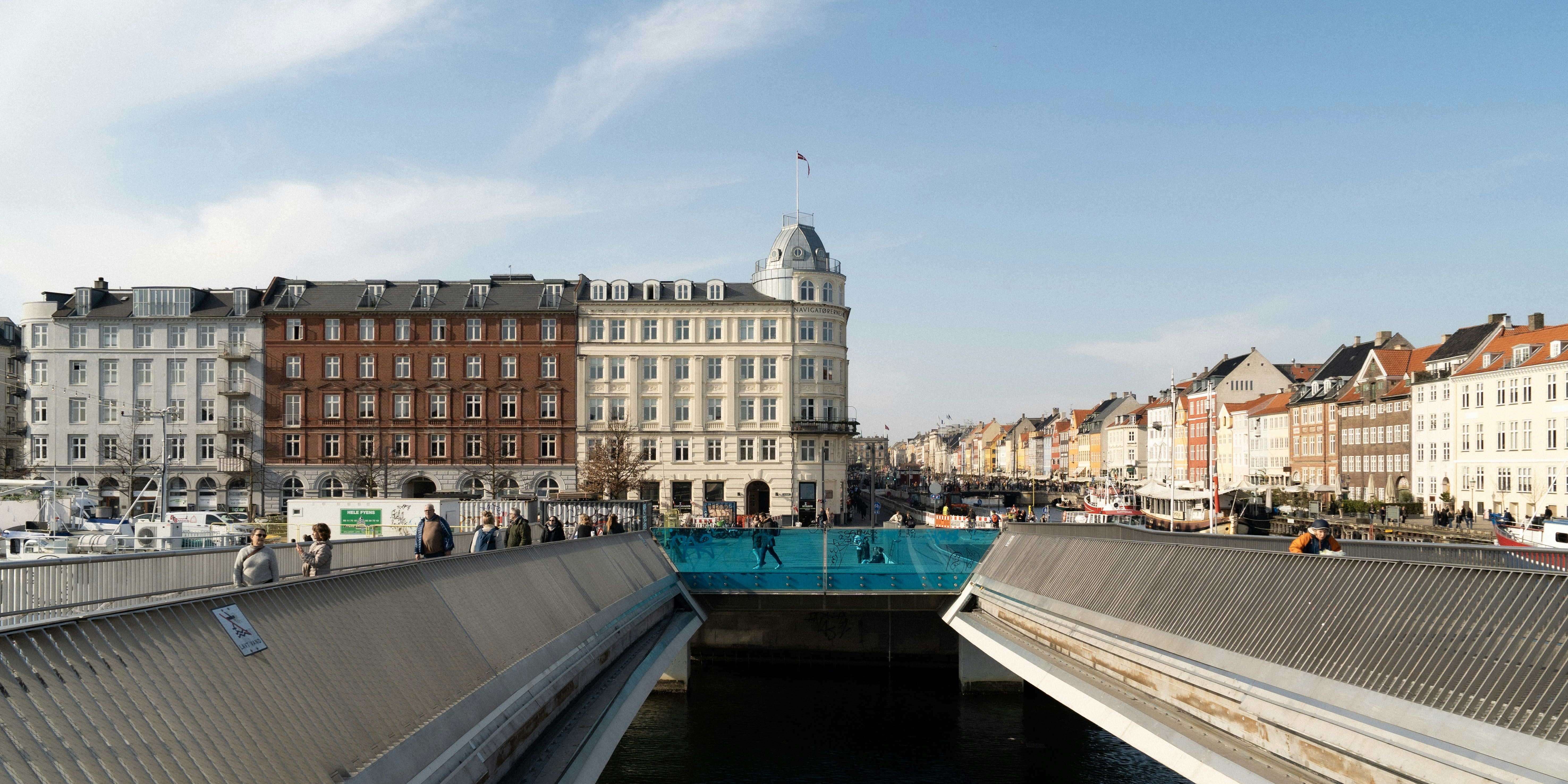 Buildings line a canal under a bright blue sky.