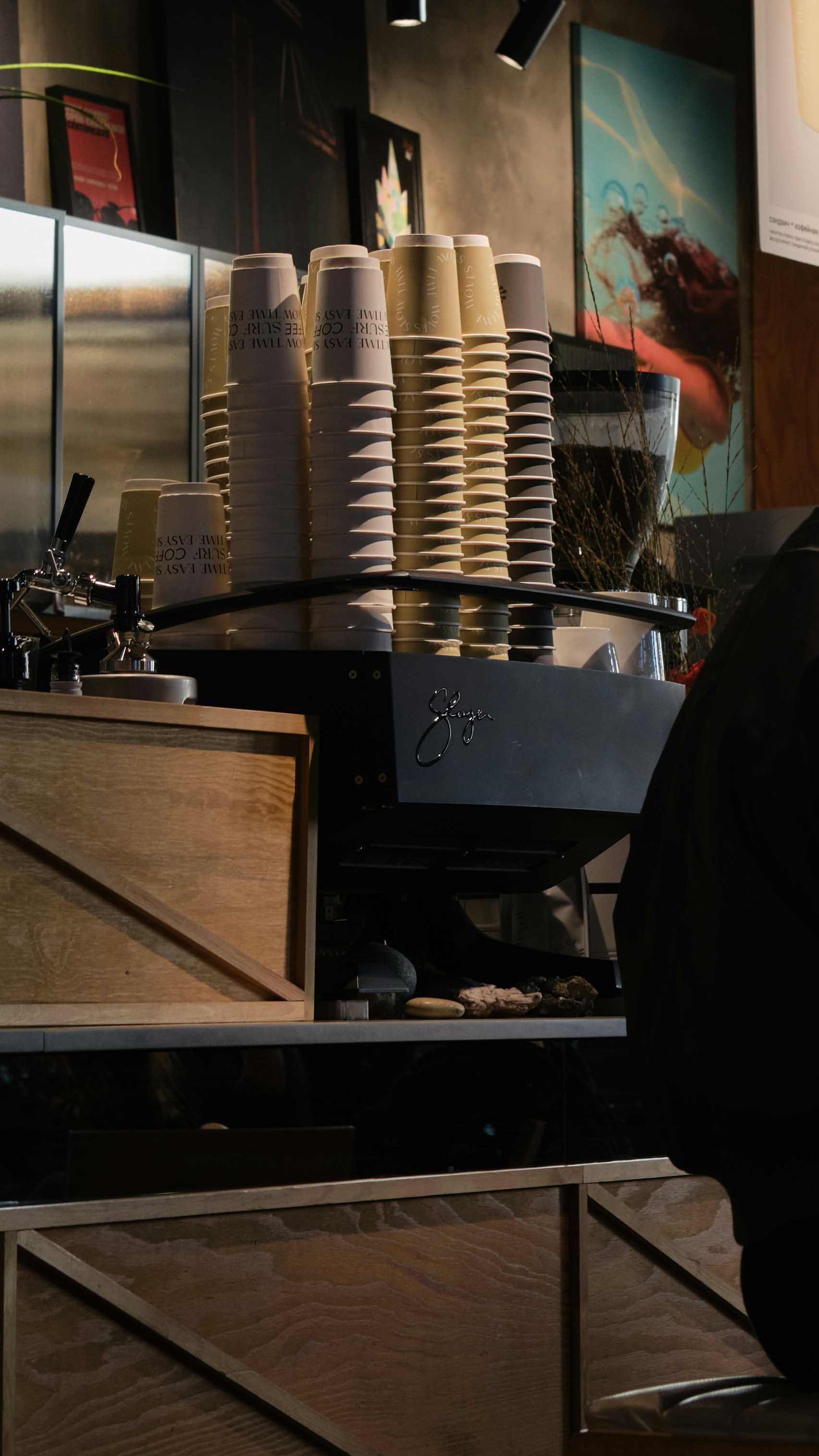 Stacks of disposable coffee cups at a cafe counter.