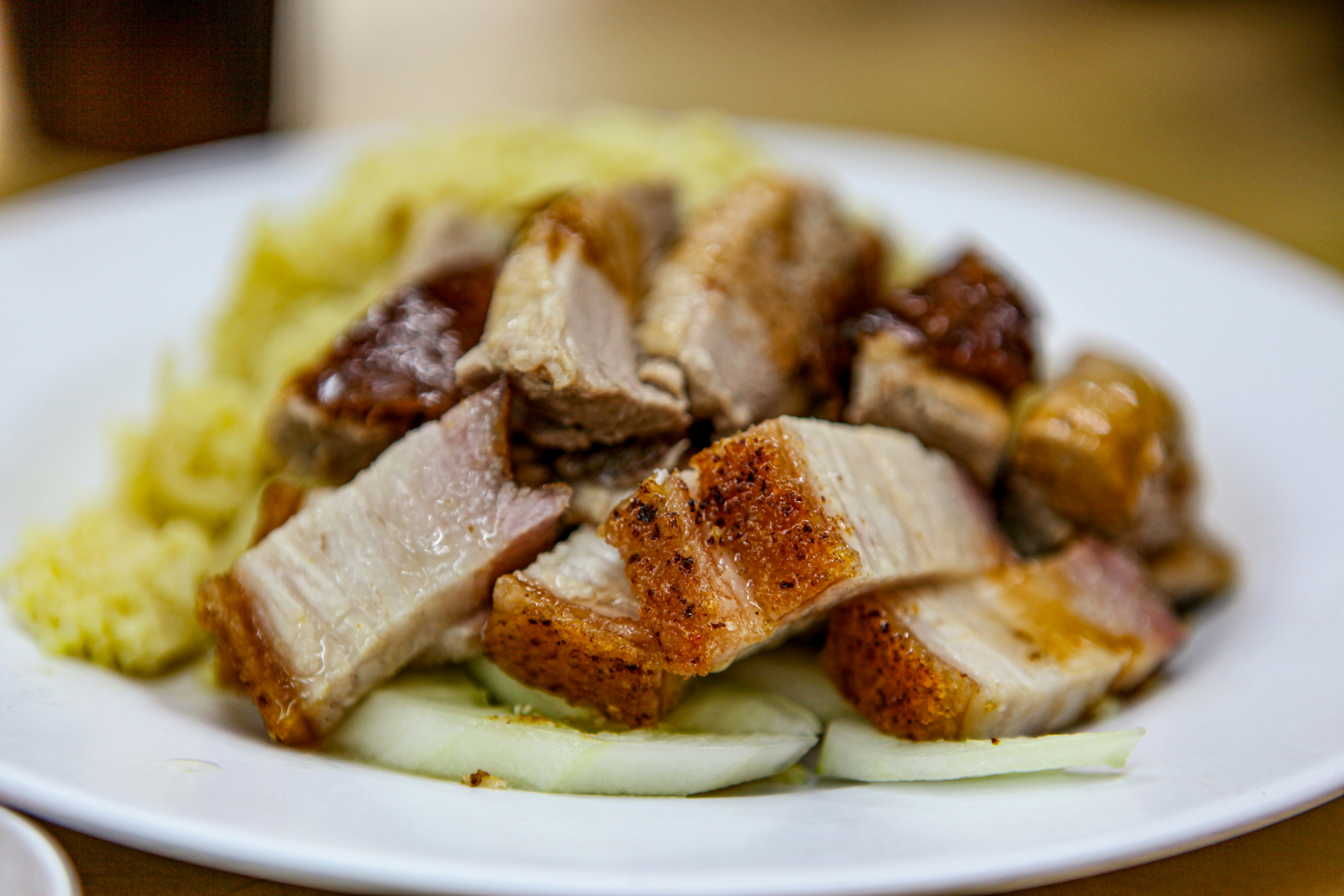 Crispy roasted pork belly served with noodles and cucumber.