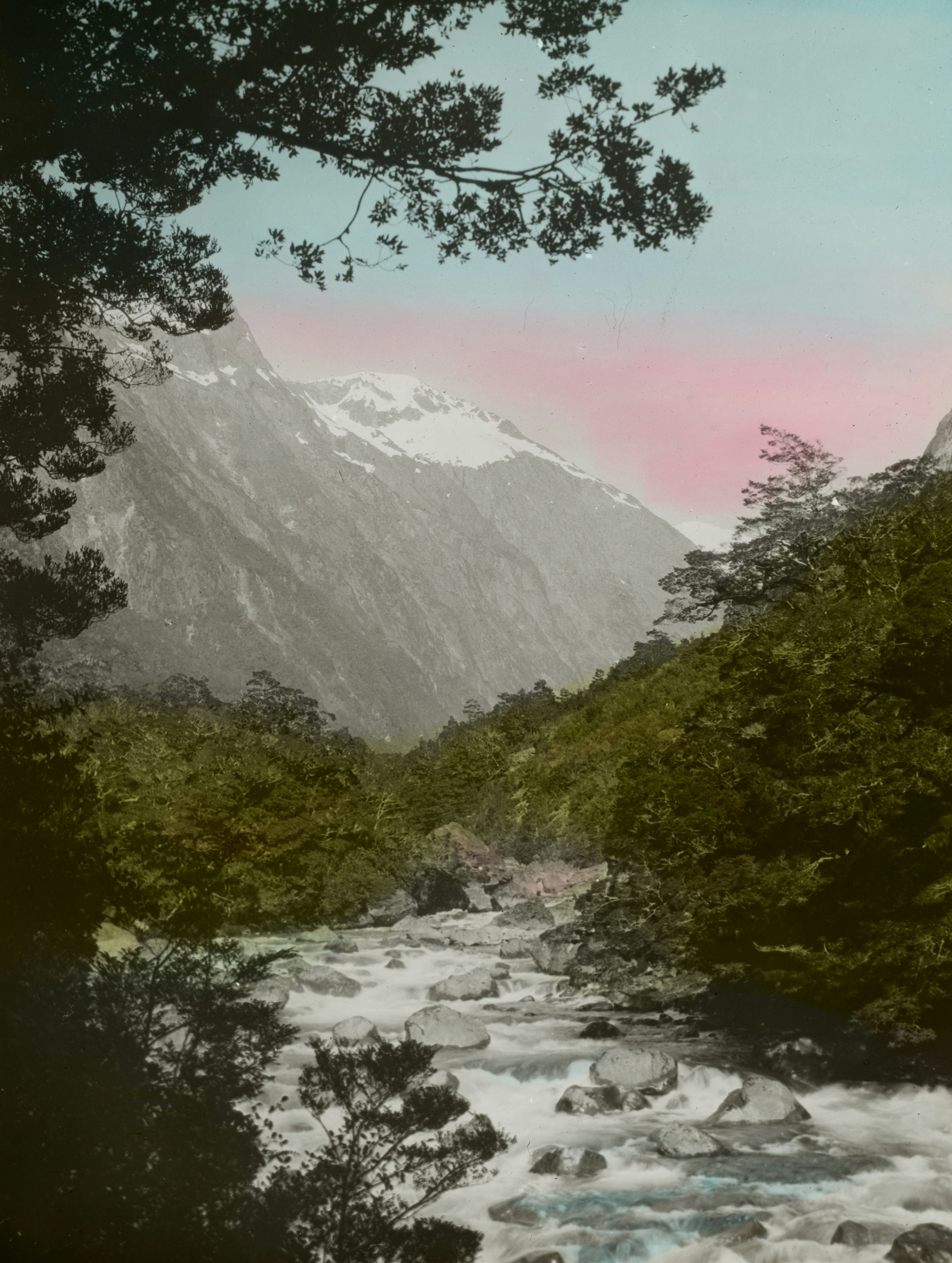 Lush green valley with a flowing river framed by towering mountains and a pastel sky. Snow-capped peaks rise majestically in the background.