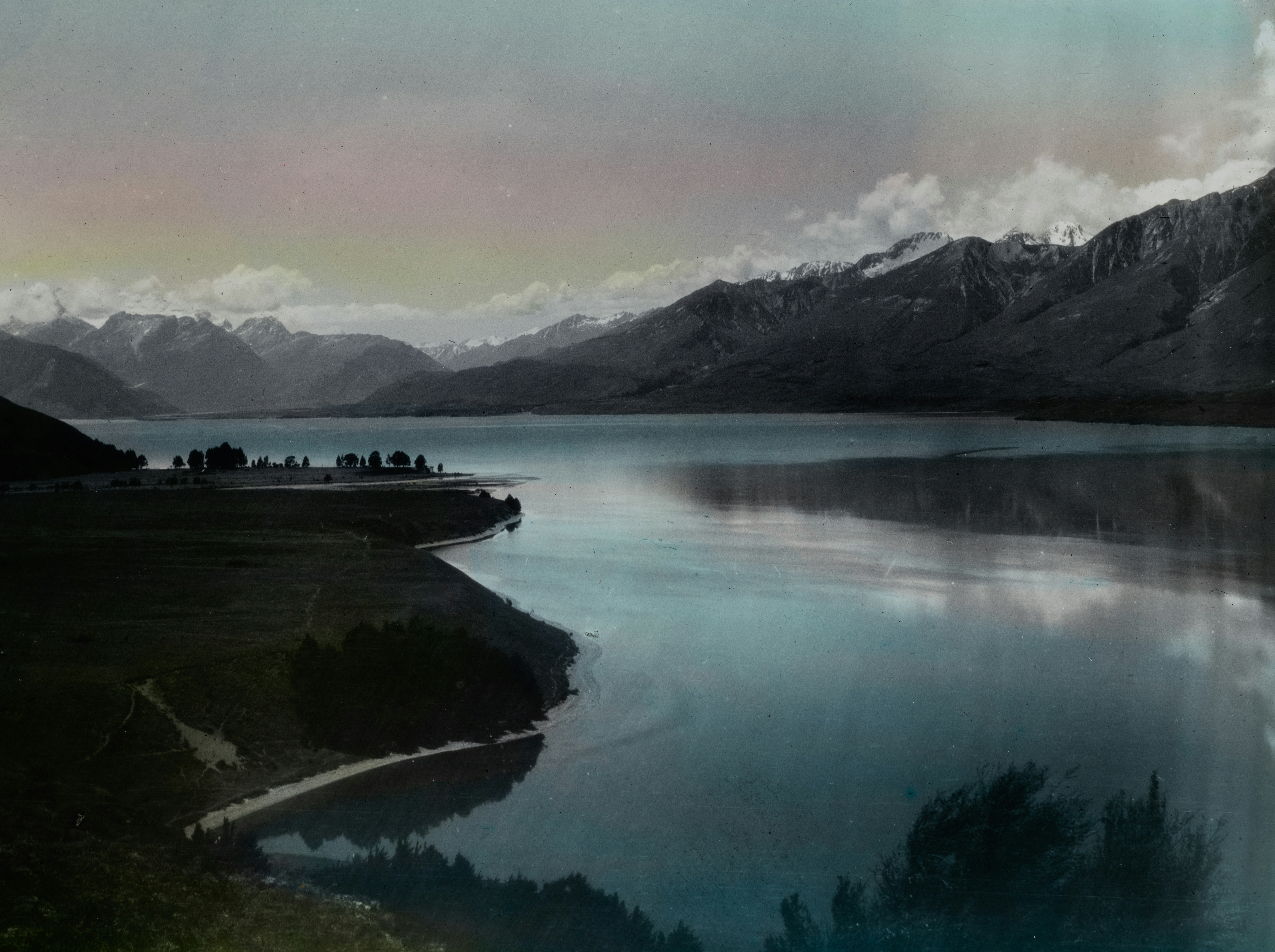 A tranquil lakeside view framed by majestic mountains under a pastel sky, capturing the essence of nature's calmness.