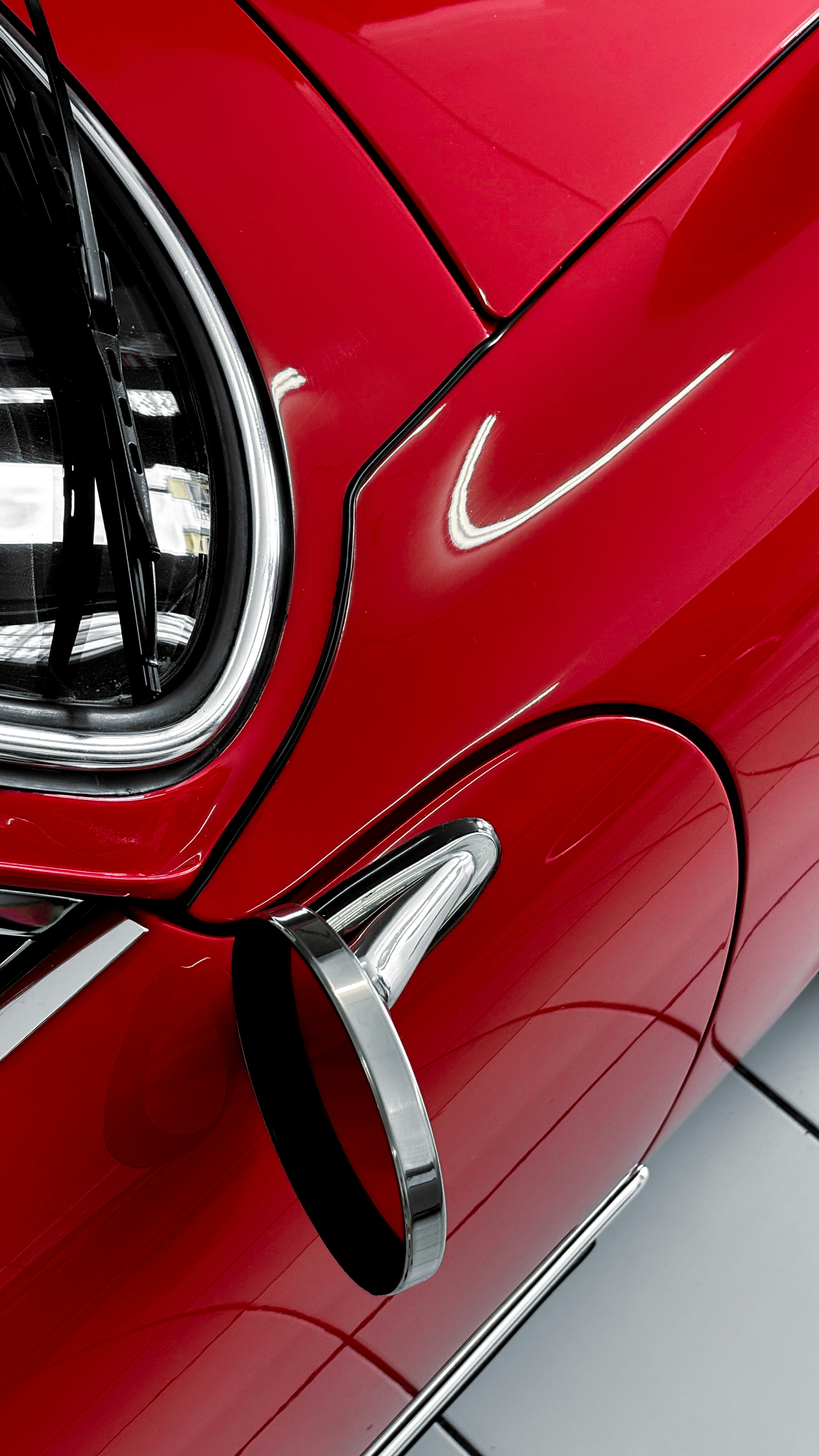 Macro detail of a red Porsche 911 T, owned by Dutchmann South Africa by Gavin Rooke. Photographed by Daniel Bayer, this image captures the essence of Porsche heritage — chrome, color, and craftsmanship in perfect balance. | Close-up of a shiny red vintage car detail.