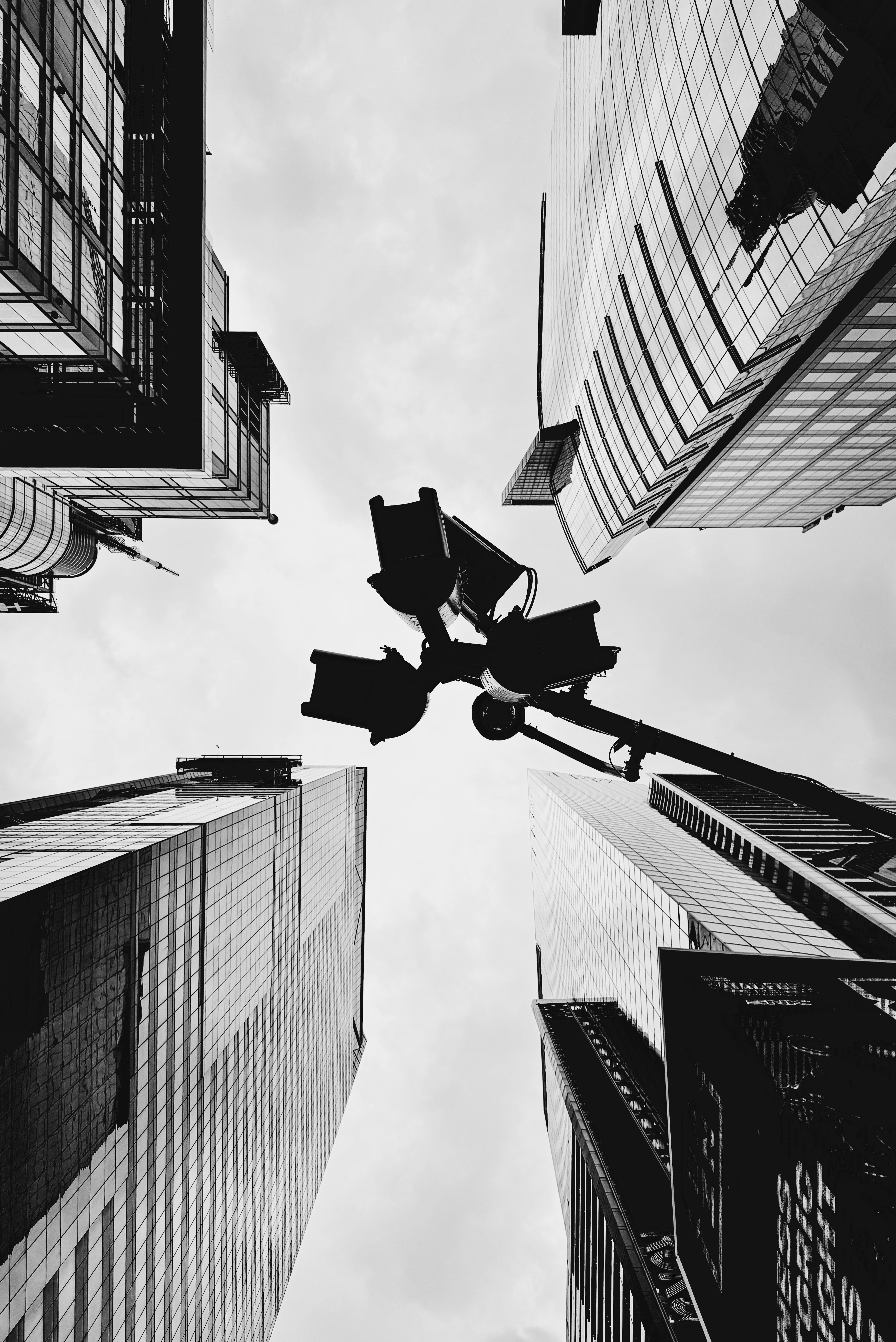 Looking up at skyscrapers and traffic lights in city.