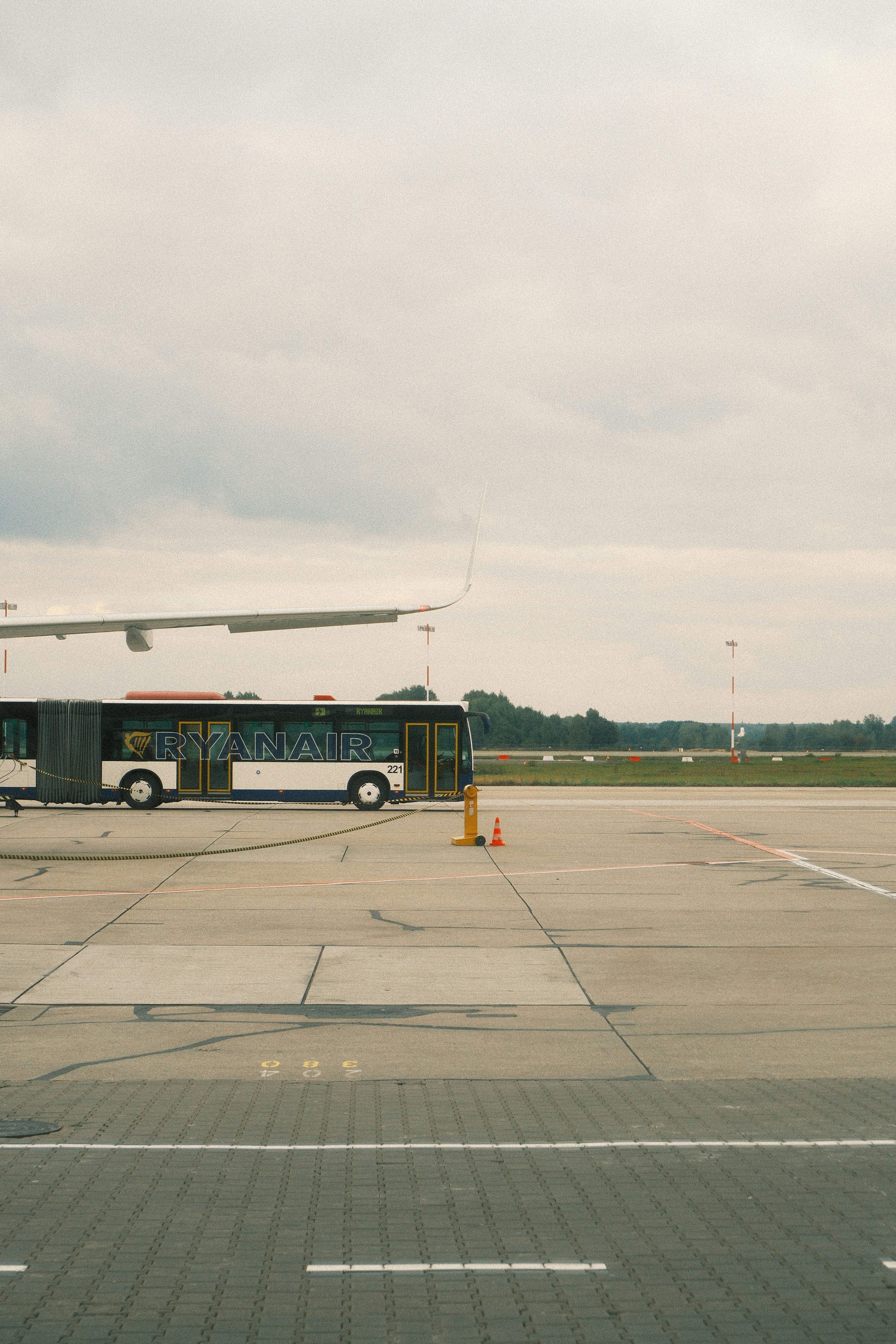 Ryanair bus parked on airport tarmac near airplane wing
