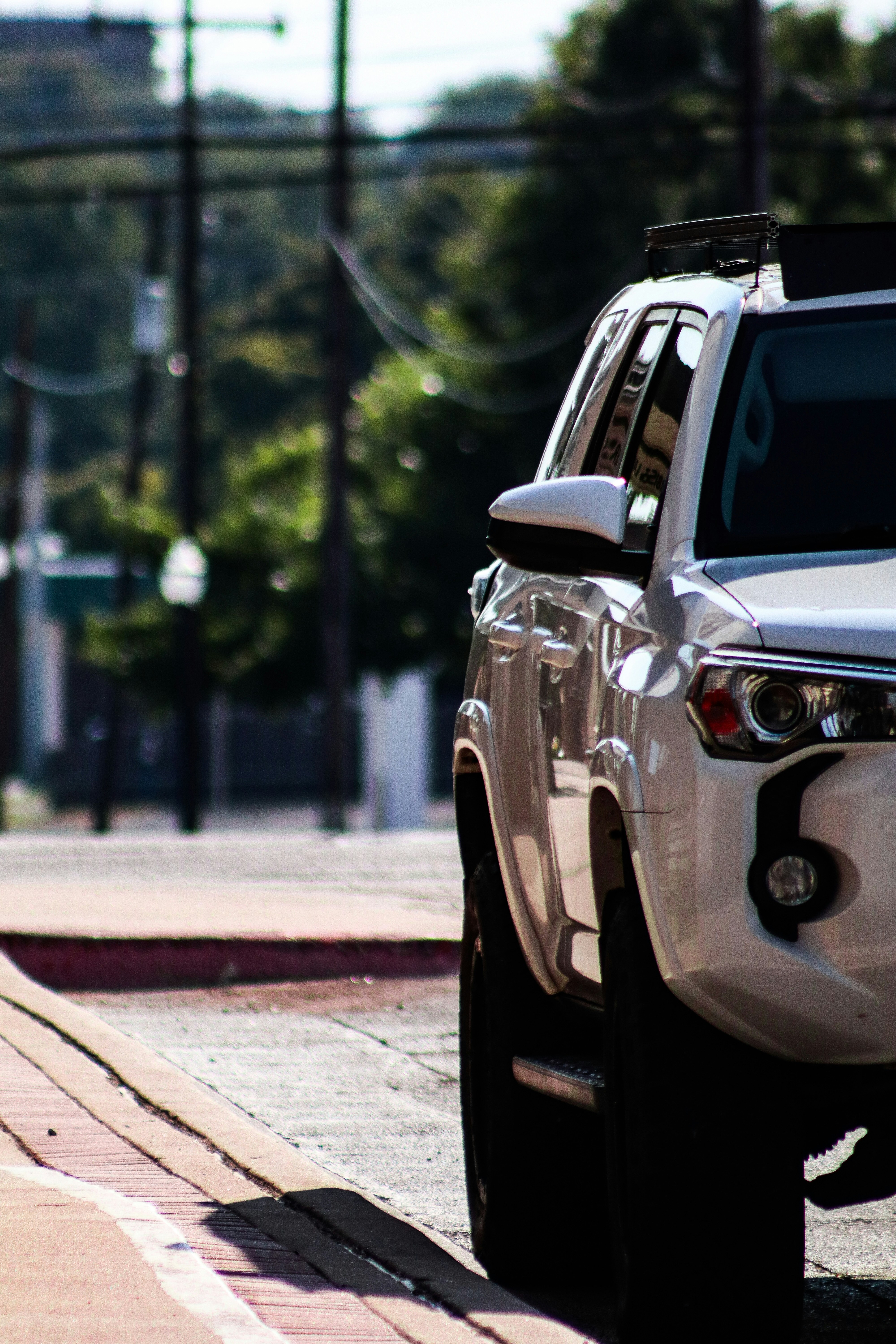 White suv parked on a brick-lined street.