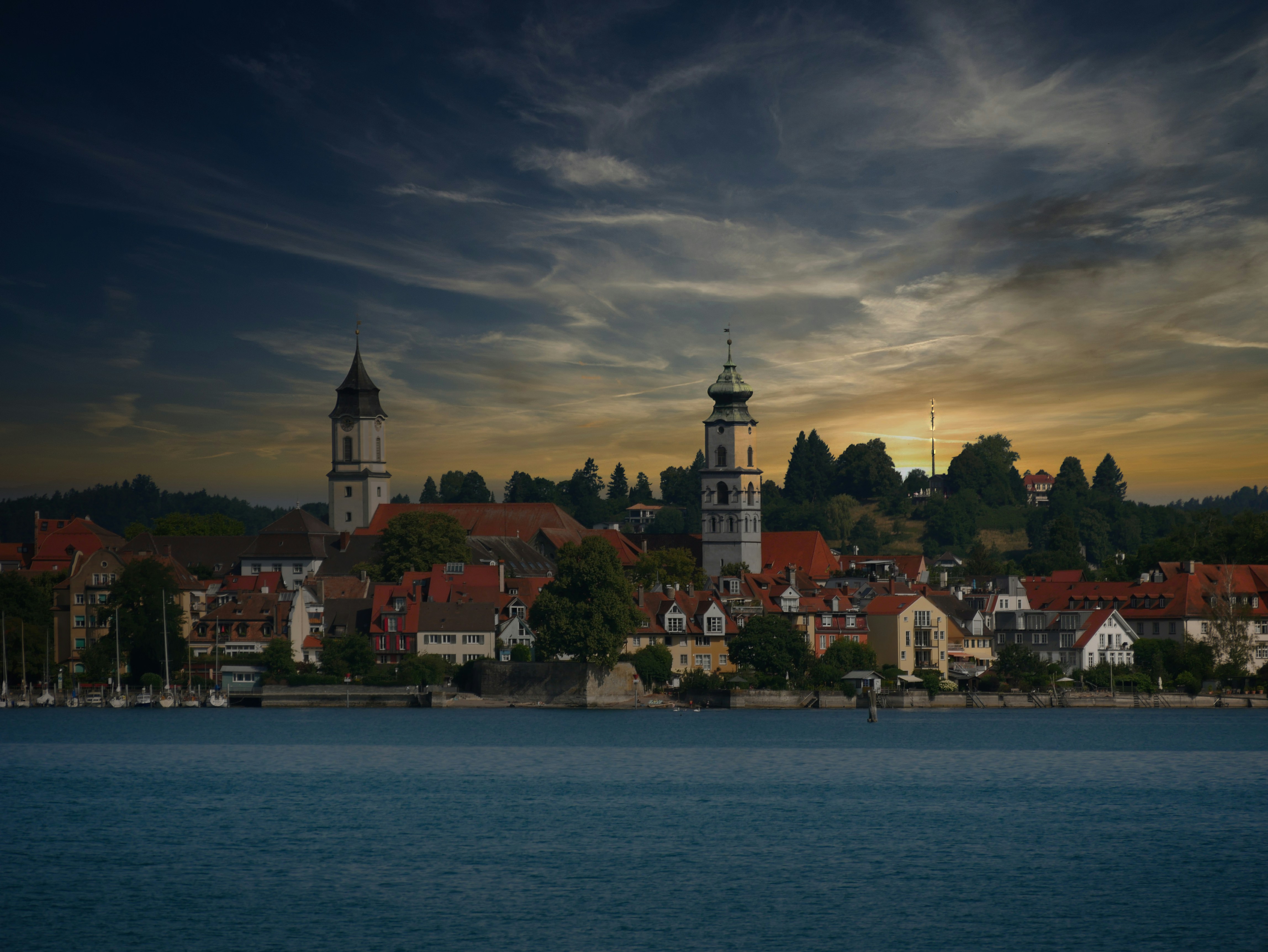 Historic european town skyline at dusk over water.