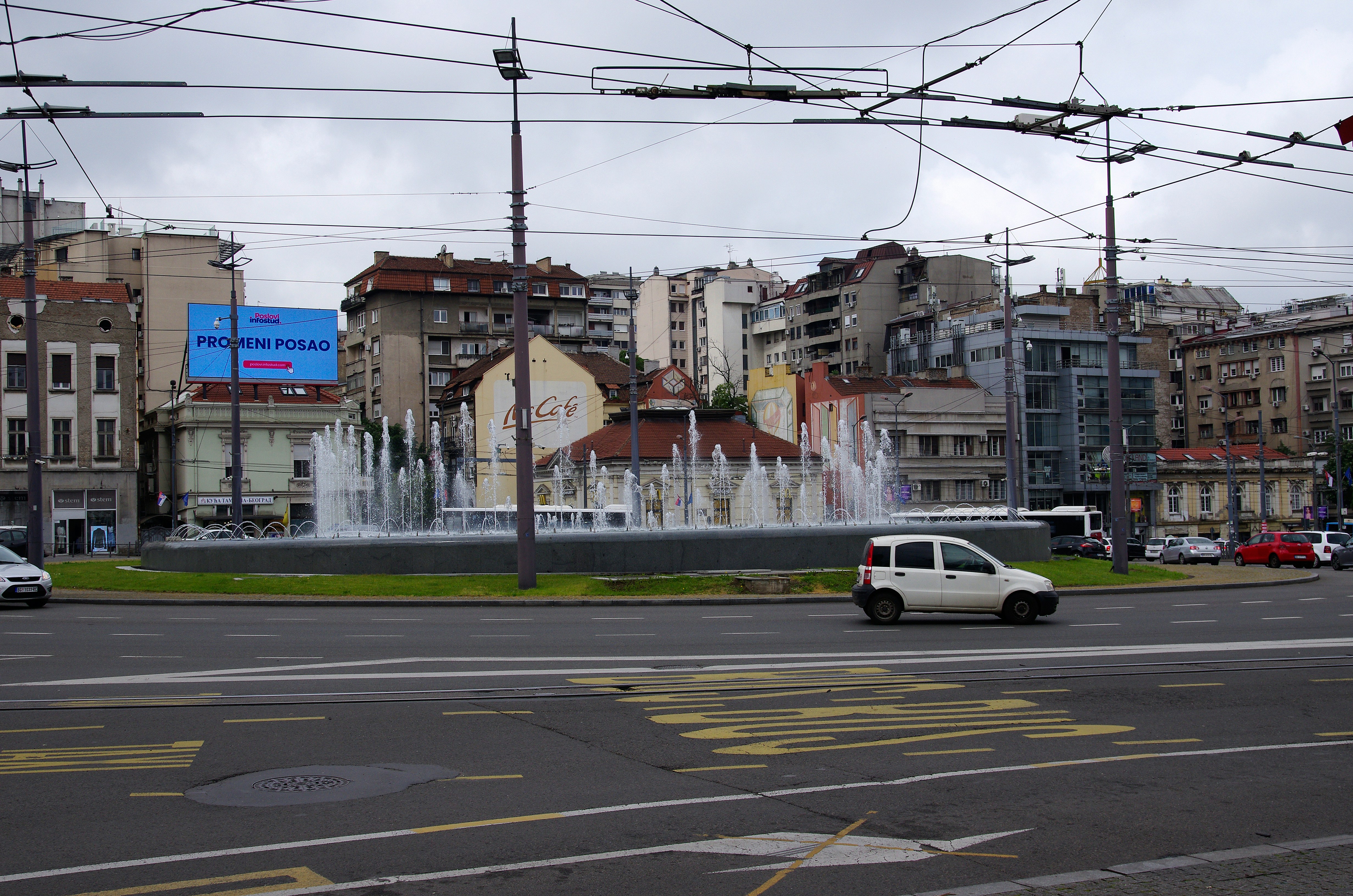 A vibrant fountain surrounded by urban architecture, showcasing the dynamic interaction between nature and city life.