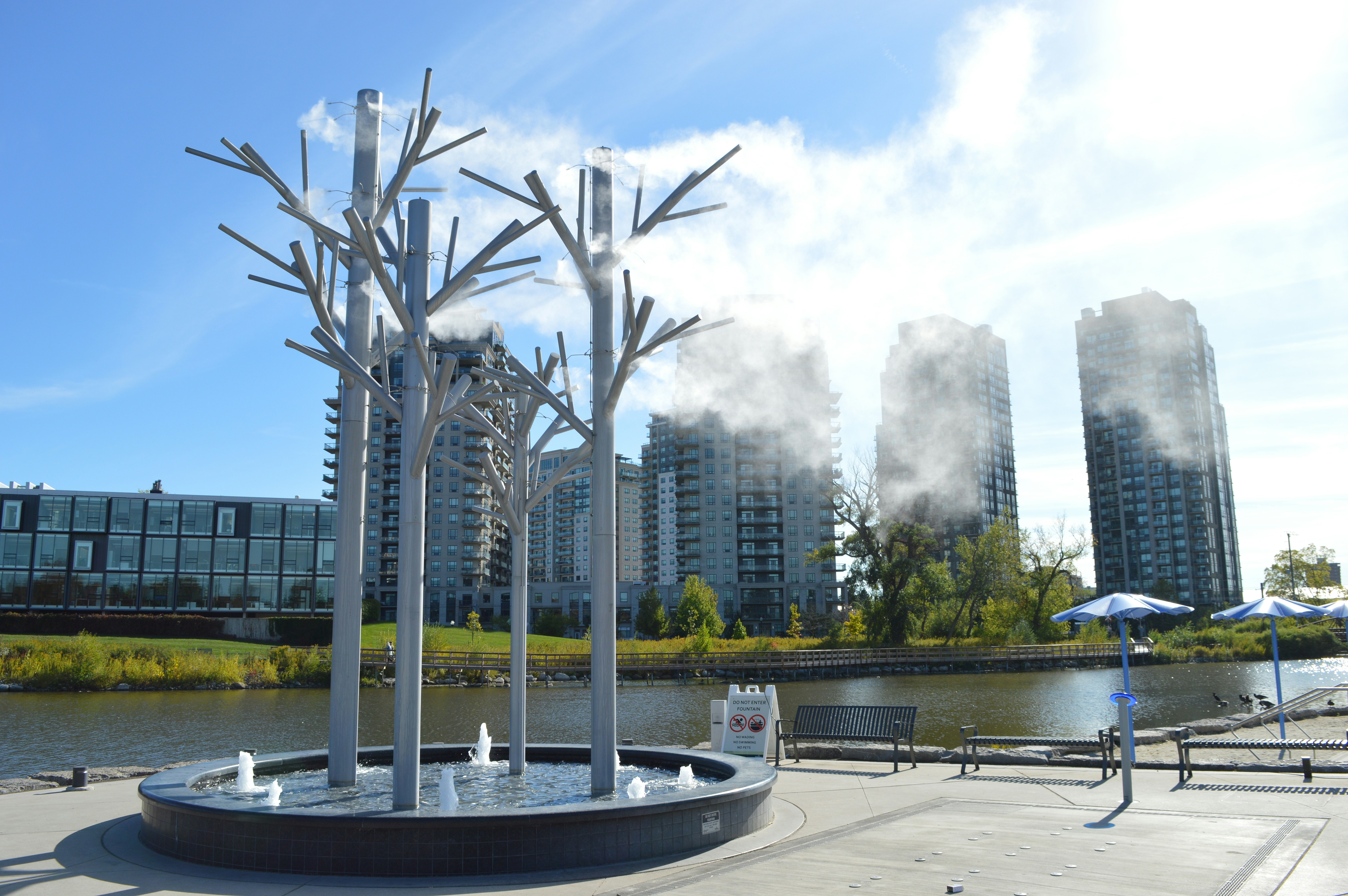 Leafless Metal Trees Guard a City Riverfront