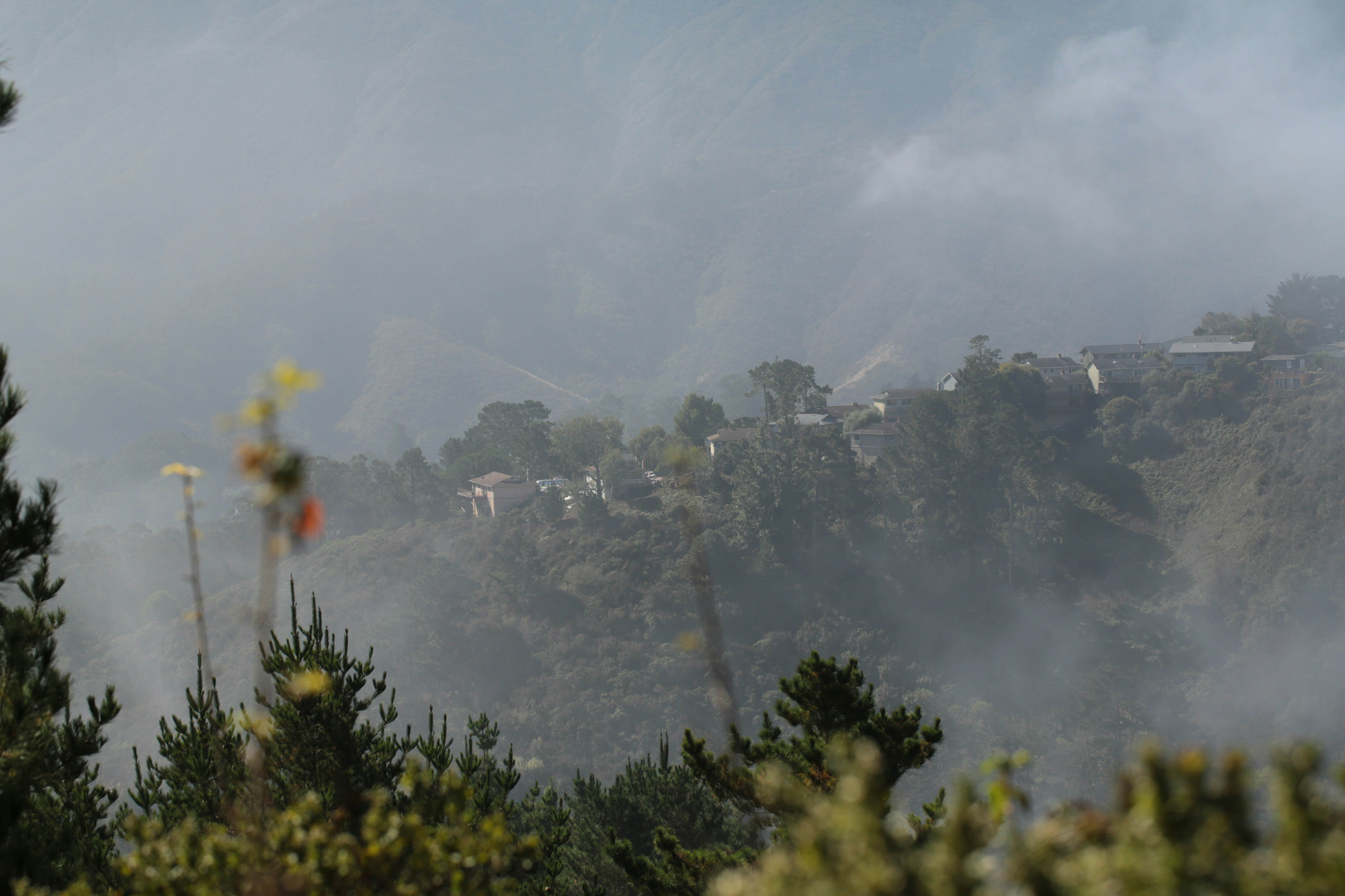Misty mountains with ancient ruins on a hillside.