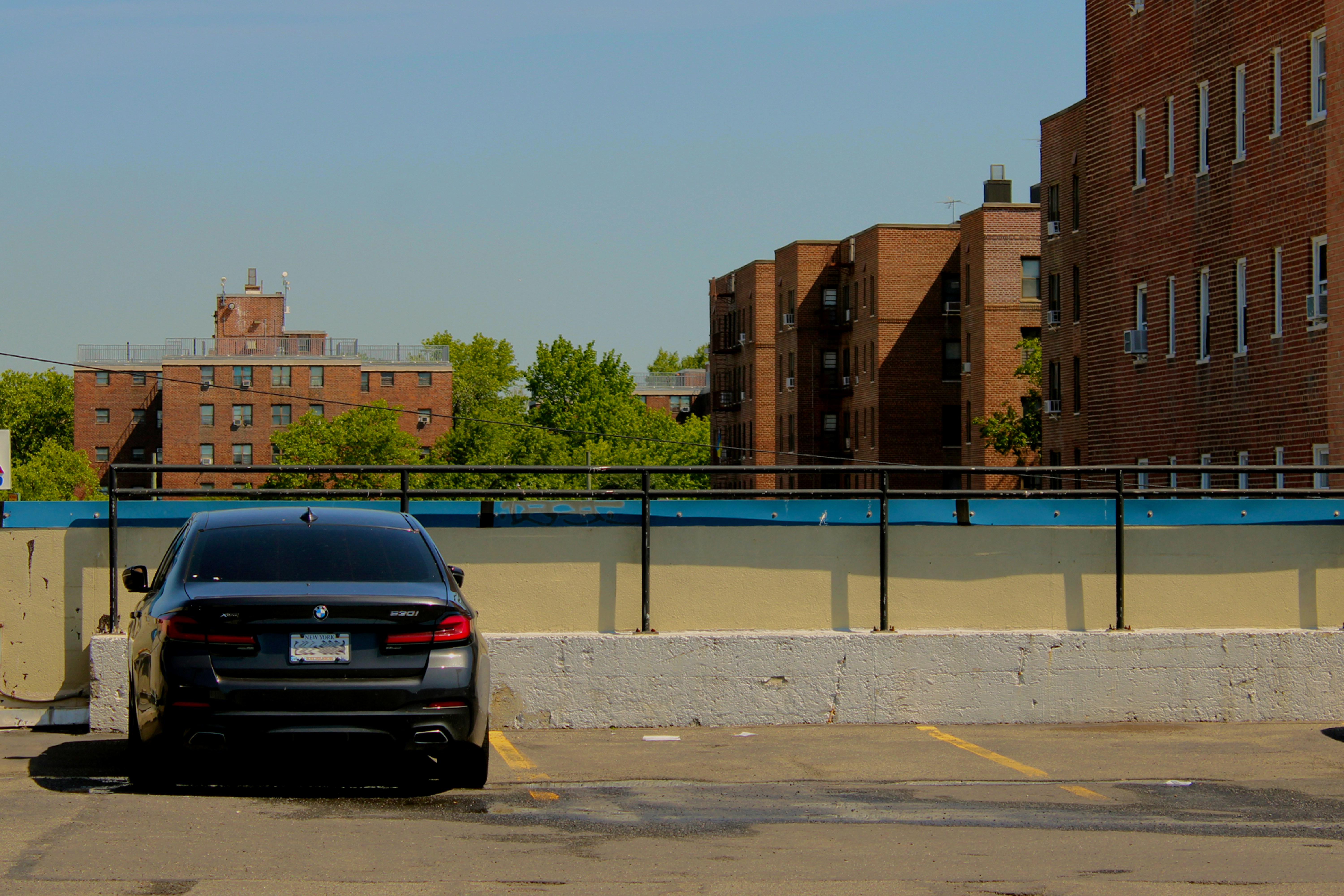 Black car parked in a sunny parking lot.