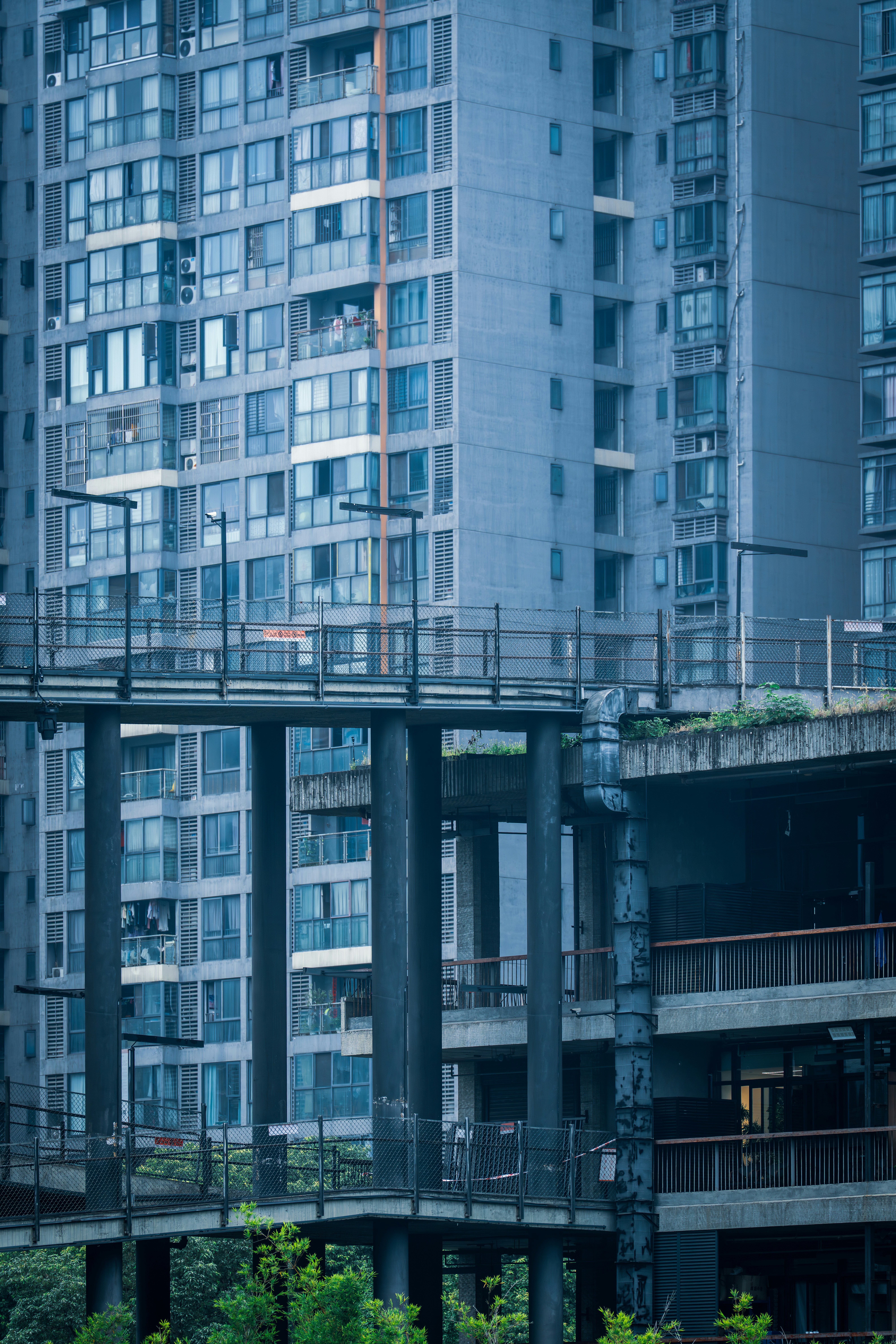 Intricate view of a multi-level urban structure juxtaposed against a backdrop of residential buildings. The scene highlights the architectural interplay of materials and design.