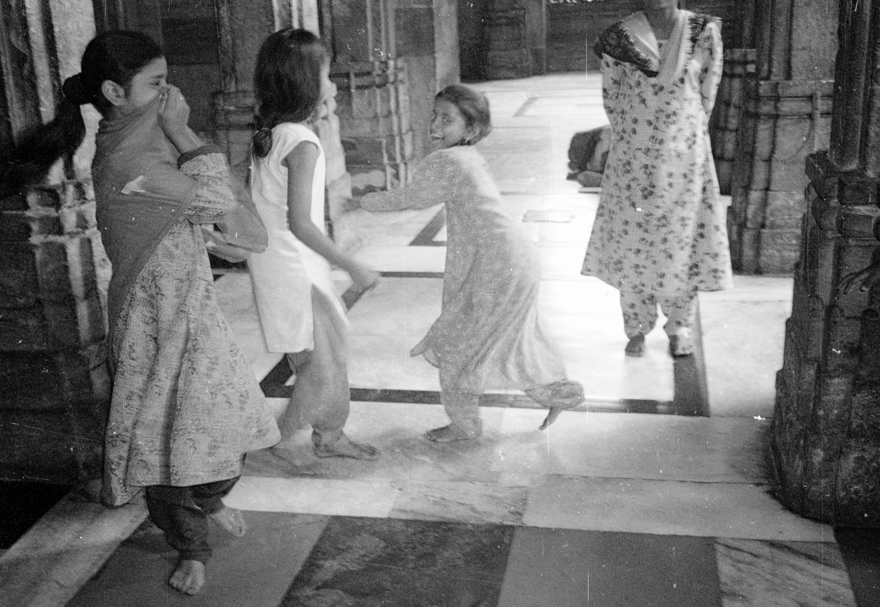 Four people stand in a tiled hallway