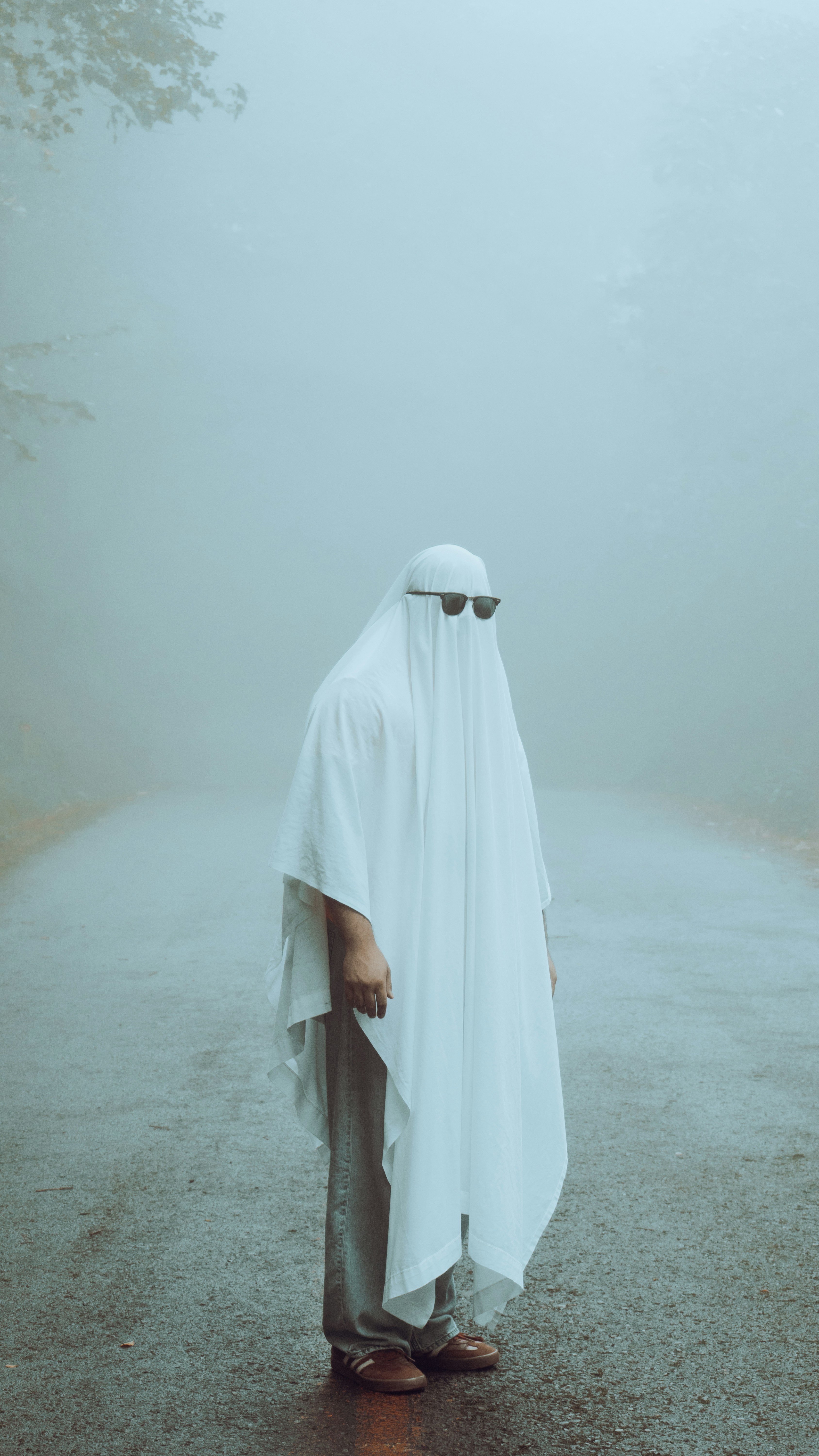 Person in a ghost costume with sunglasses on road