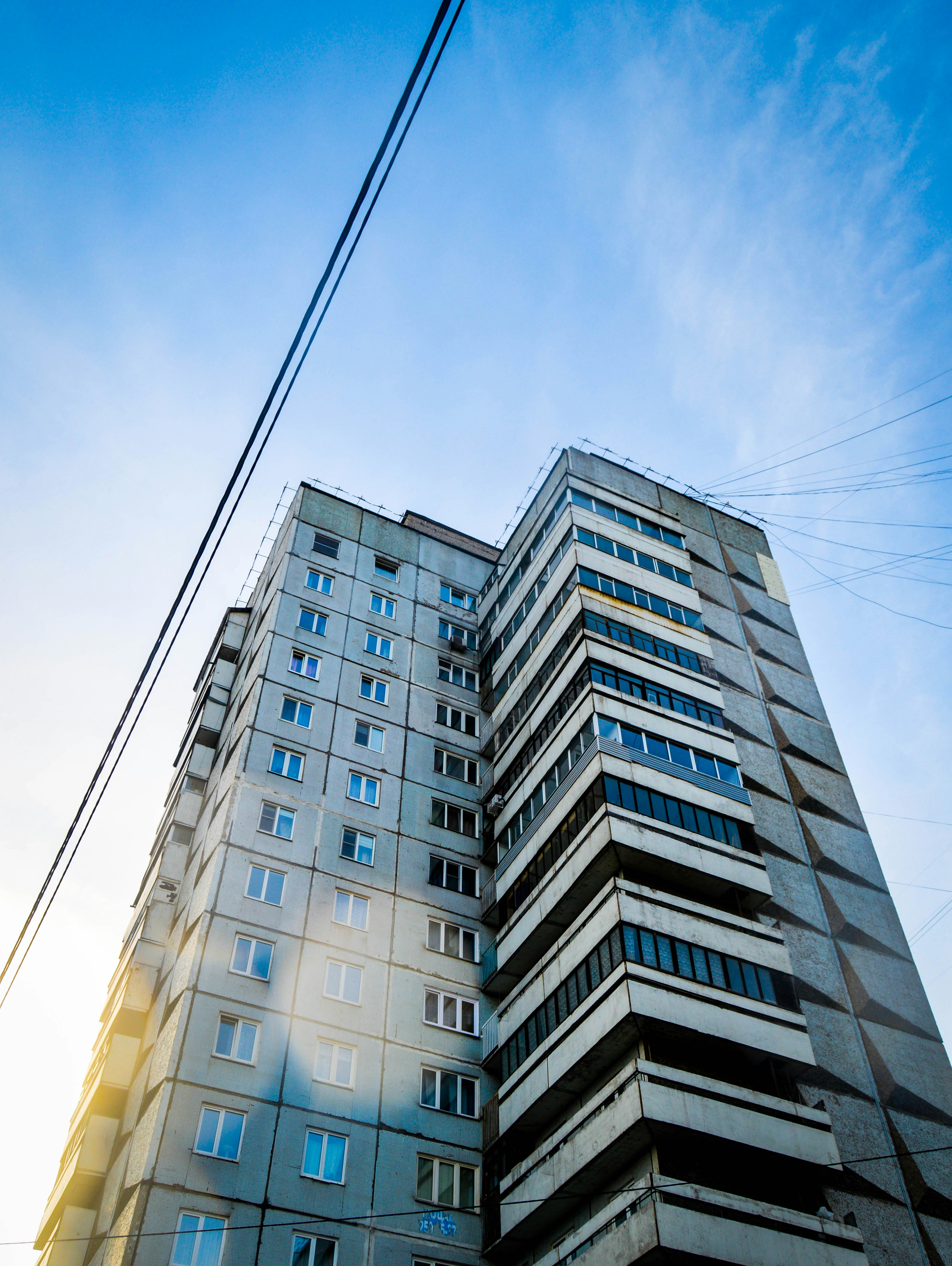 Tall apartment building against a bright blue sky