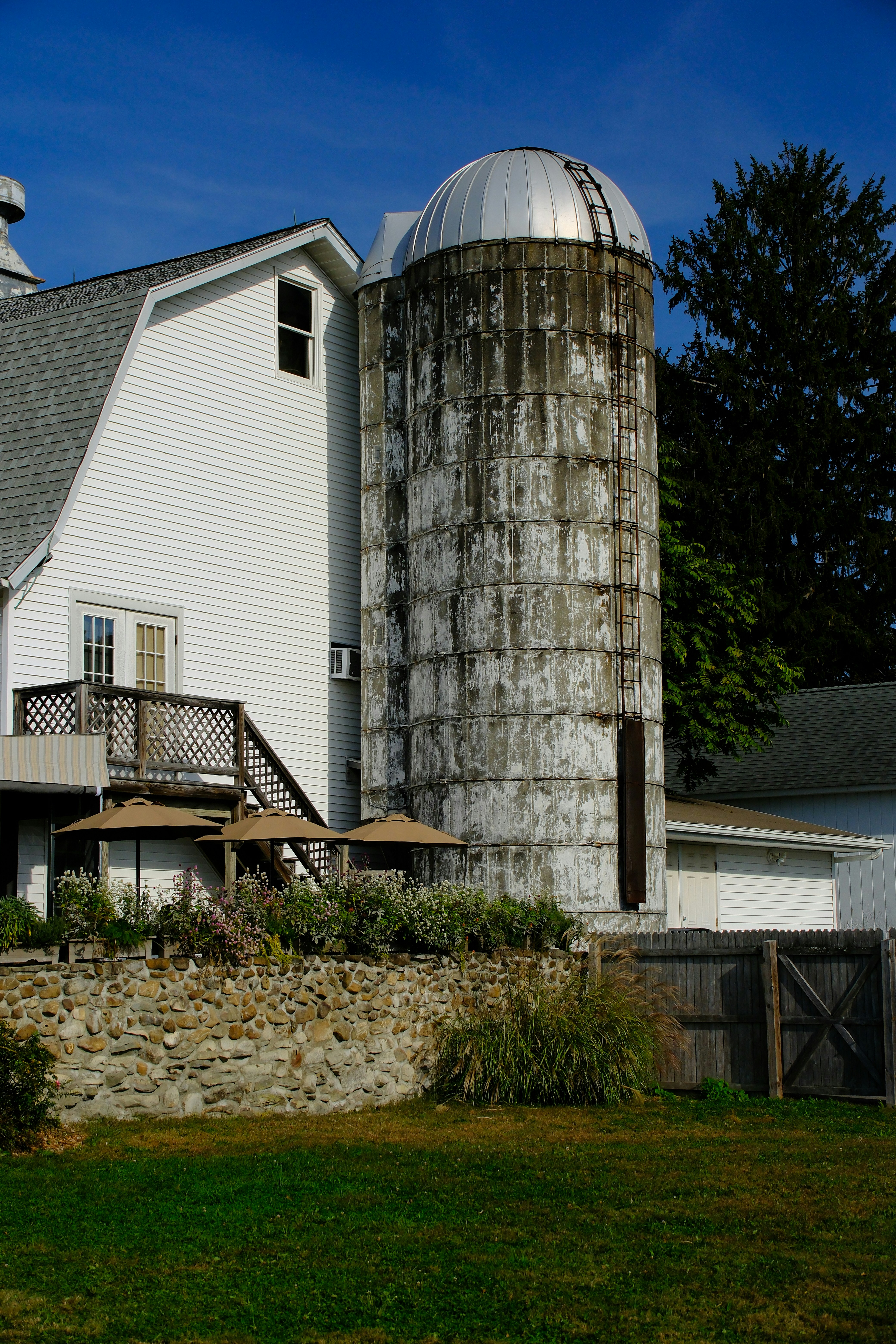 old barn | White barn with a tall silo and stone wall