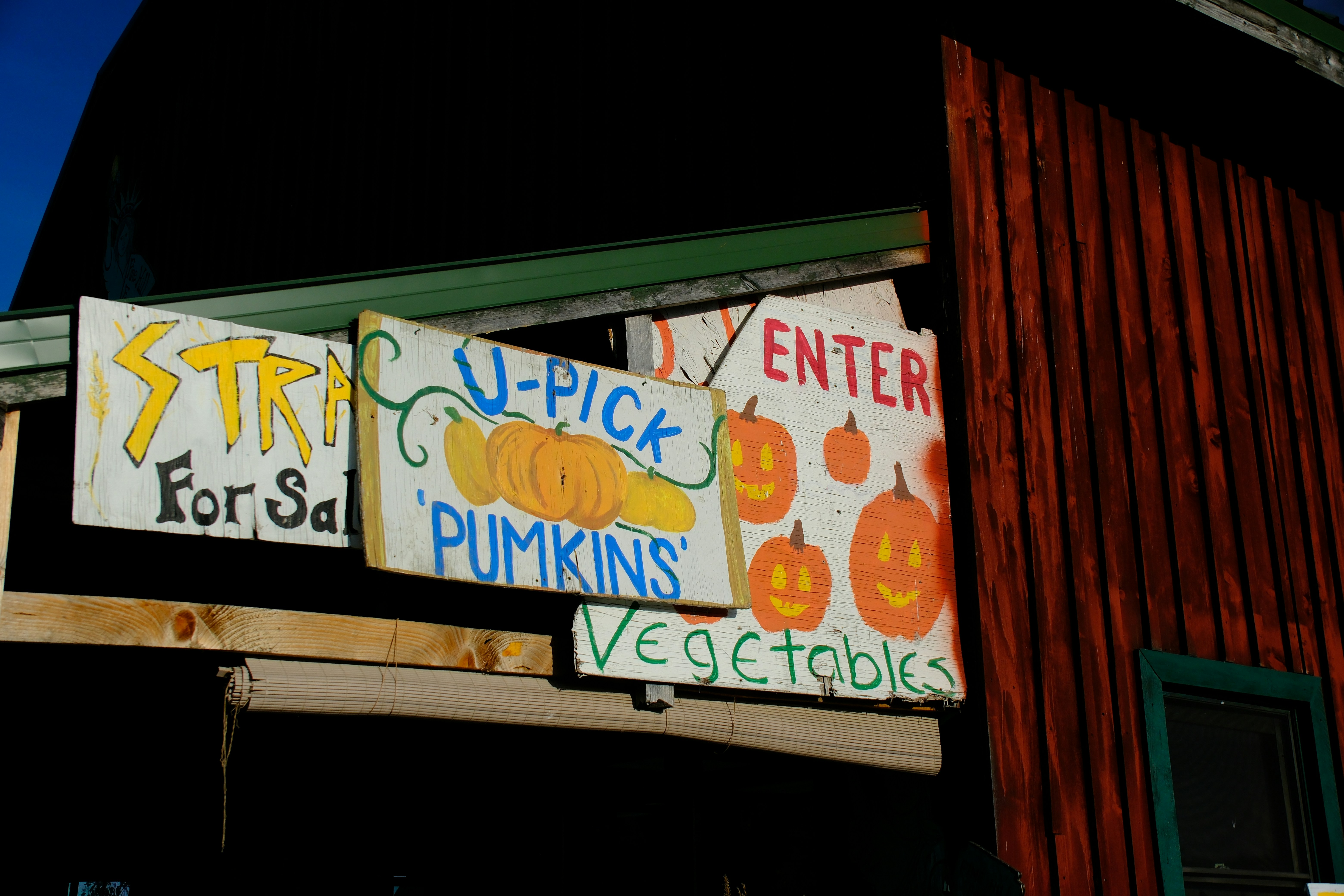 Farm stand with u-pick pumpkins and vegetables signs