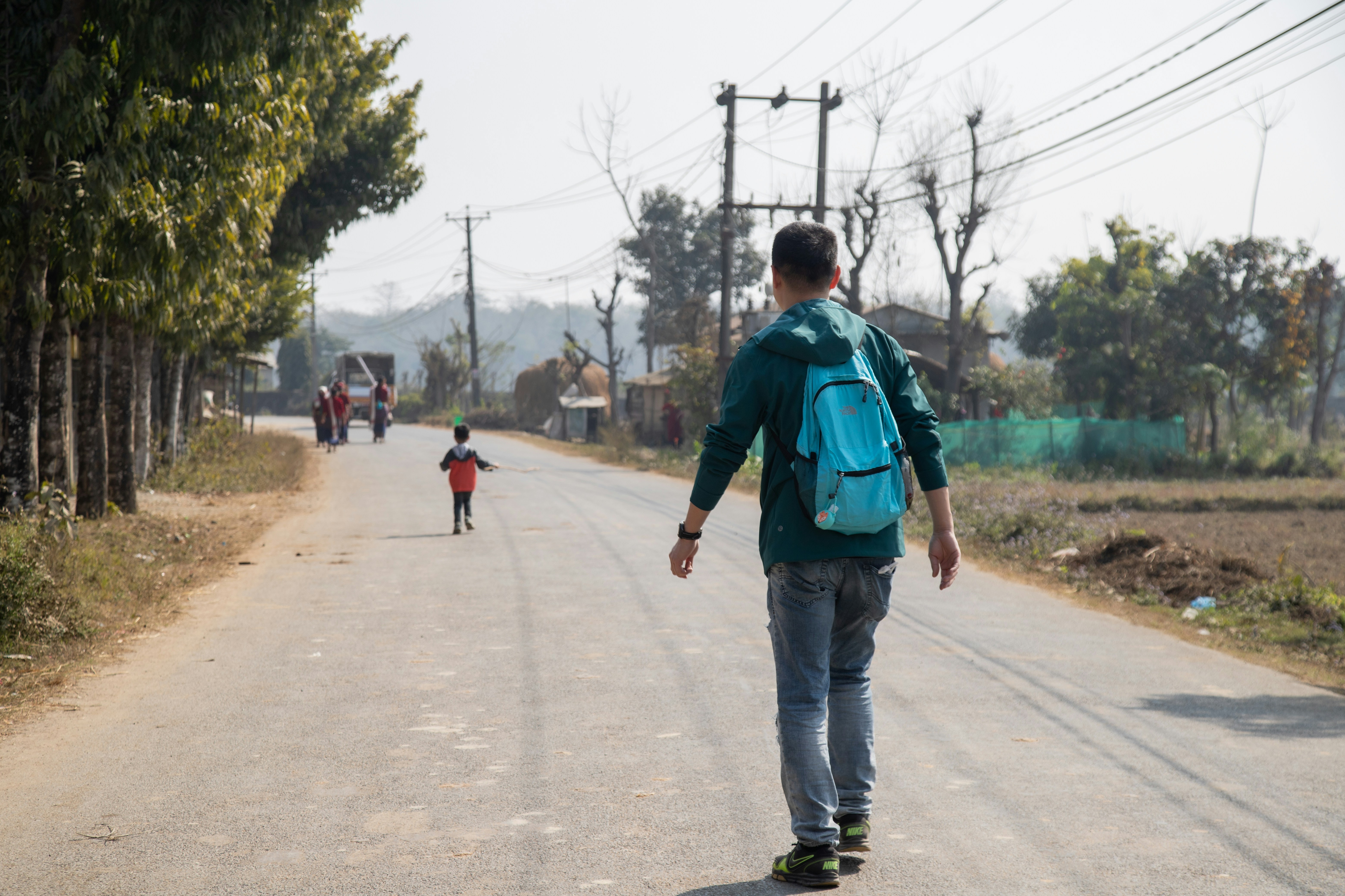 Father Rushing to Stop His Child Running Toward the Road | Man with backpack walks on road towards child.