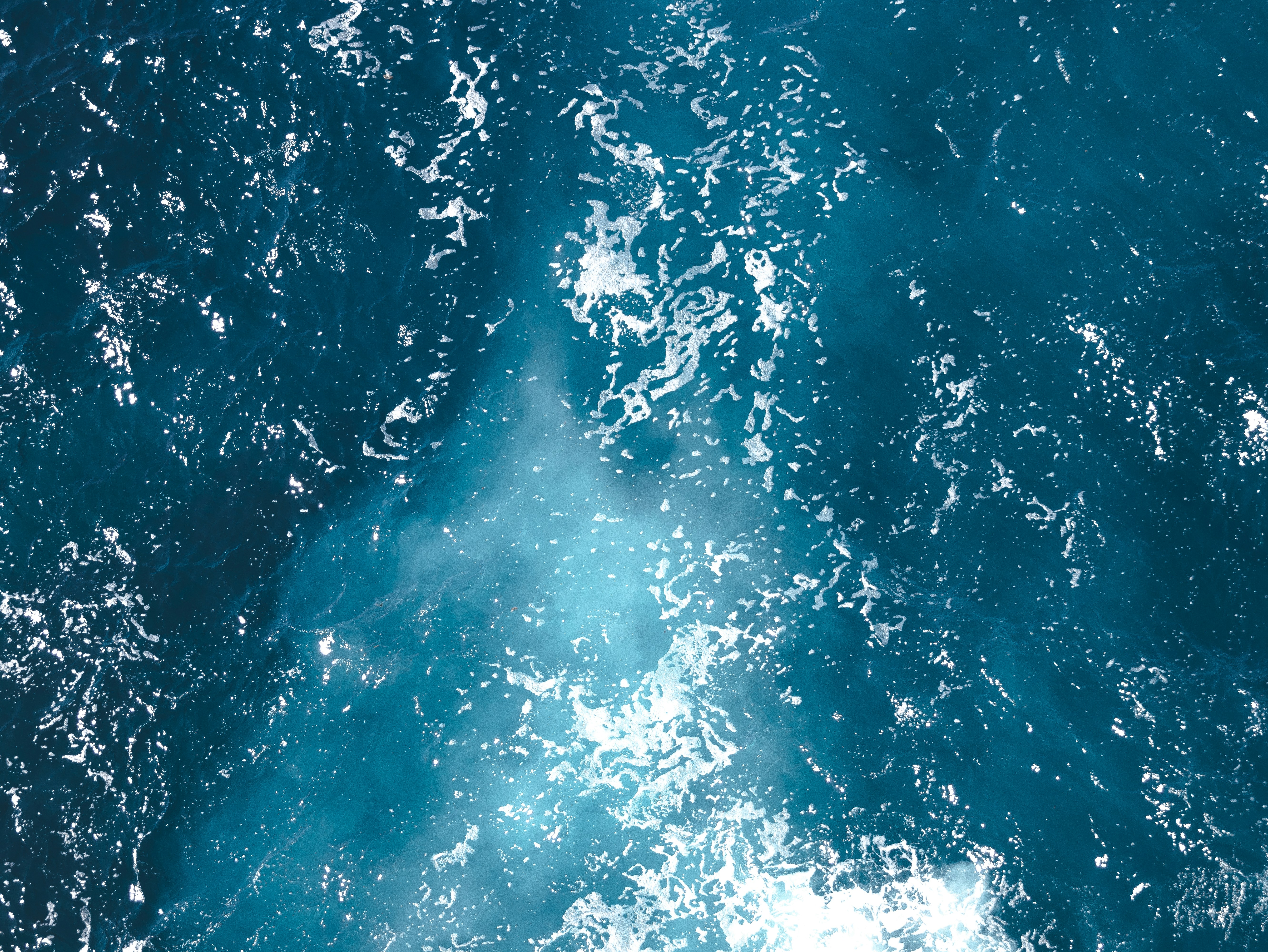 Turquoise ocean water with white foam patterns