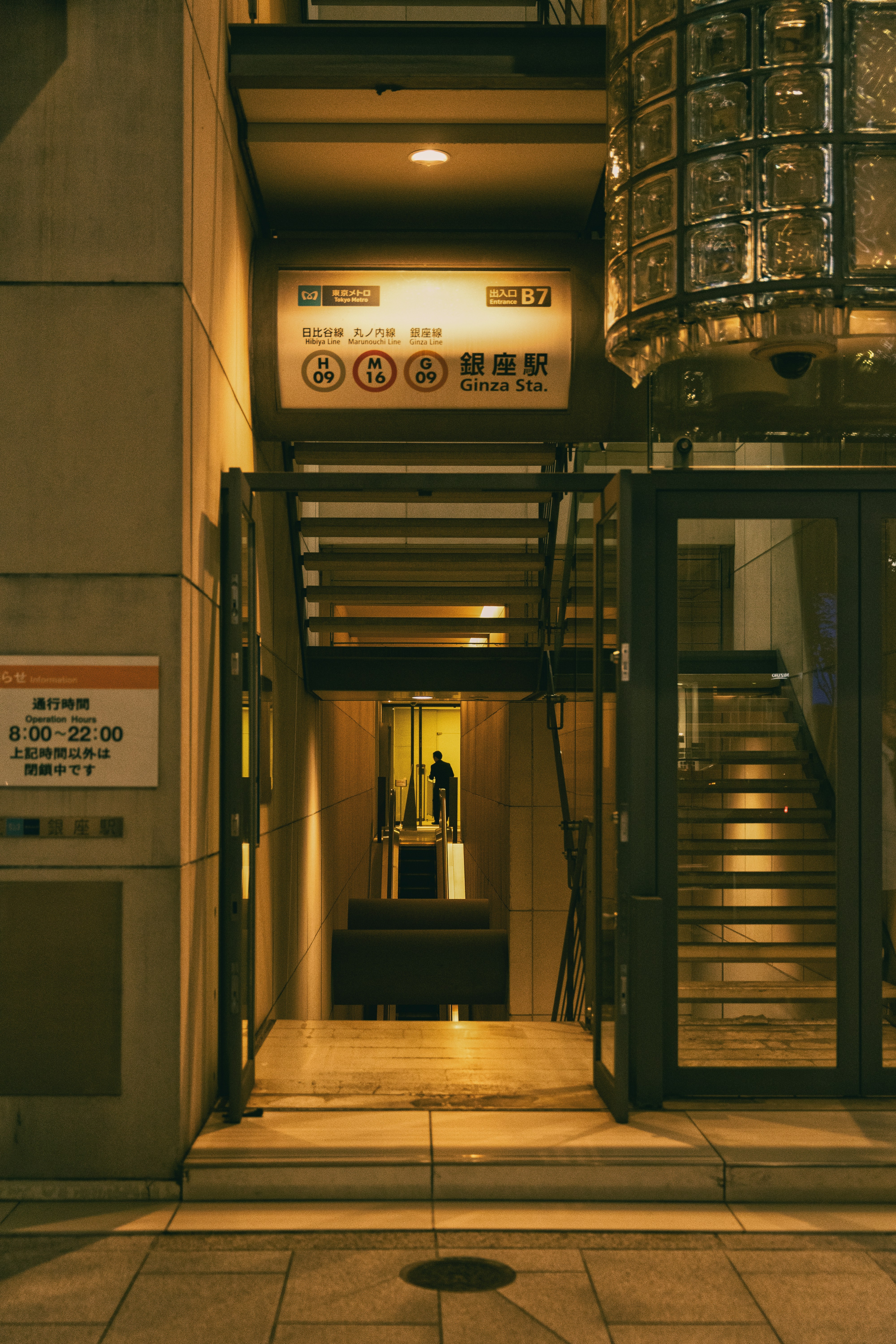 Man silhouetted at entrance of illuminated building at night