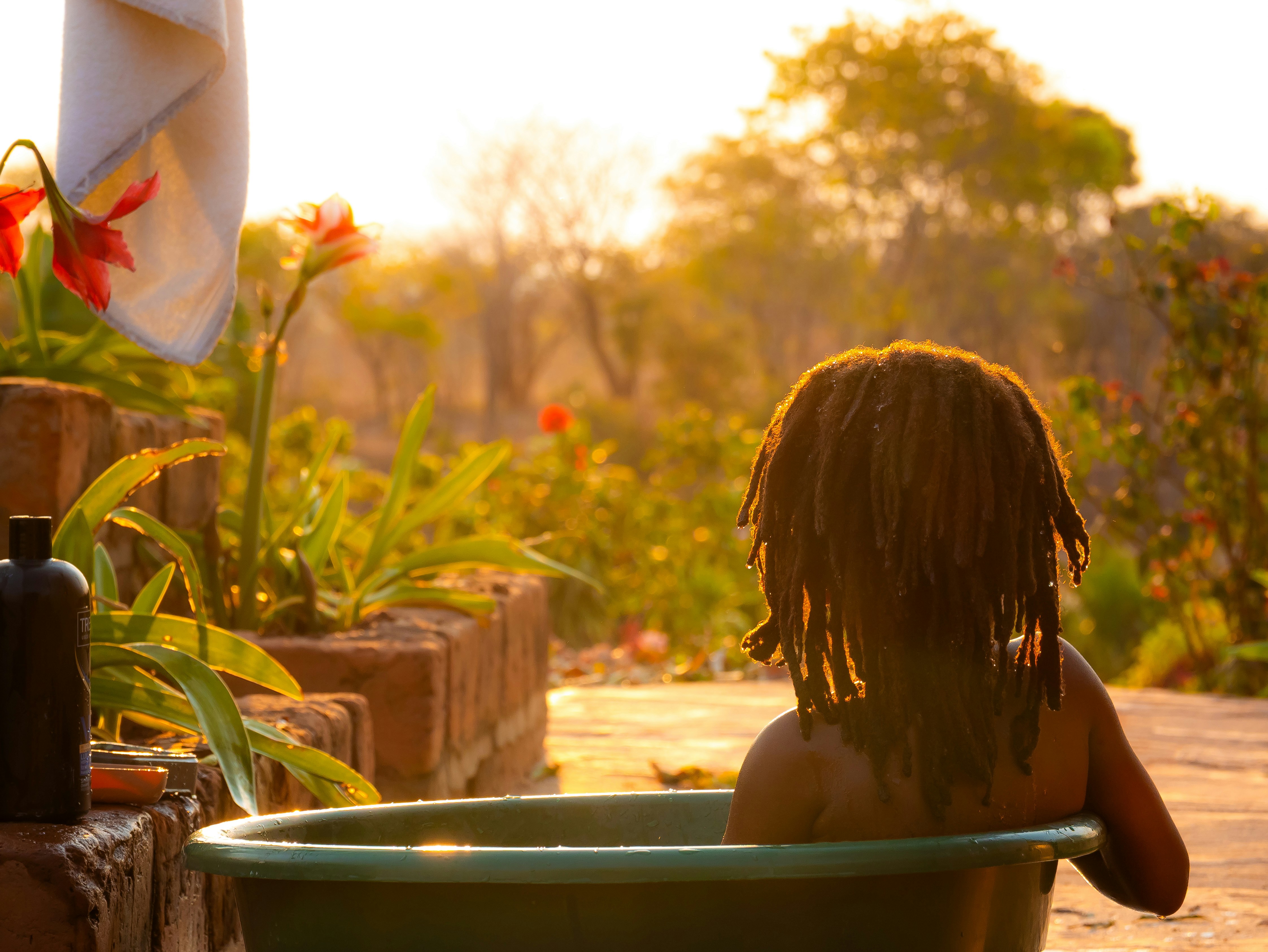 Person with dreadlocks bathing outdoors at sunset. photo – Free Flowers ...