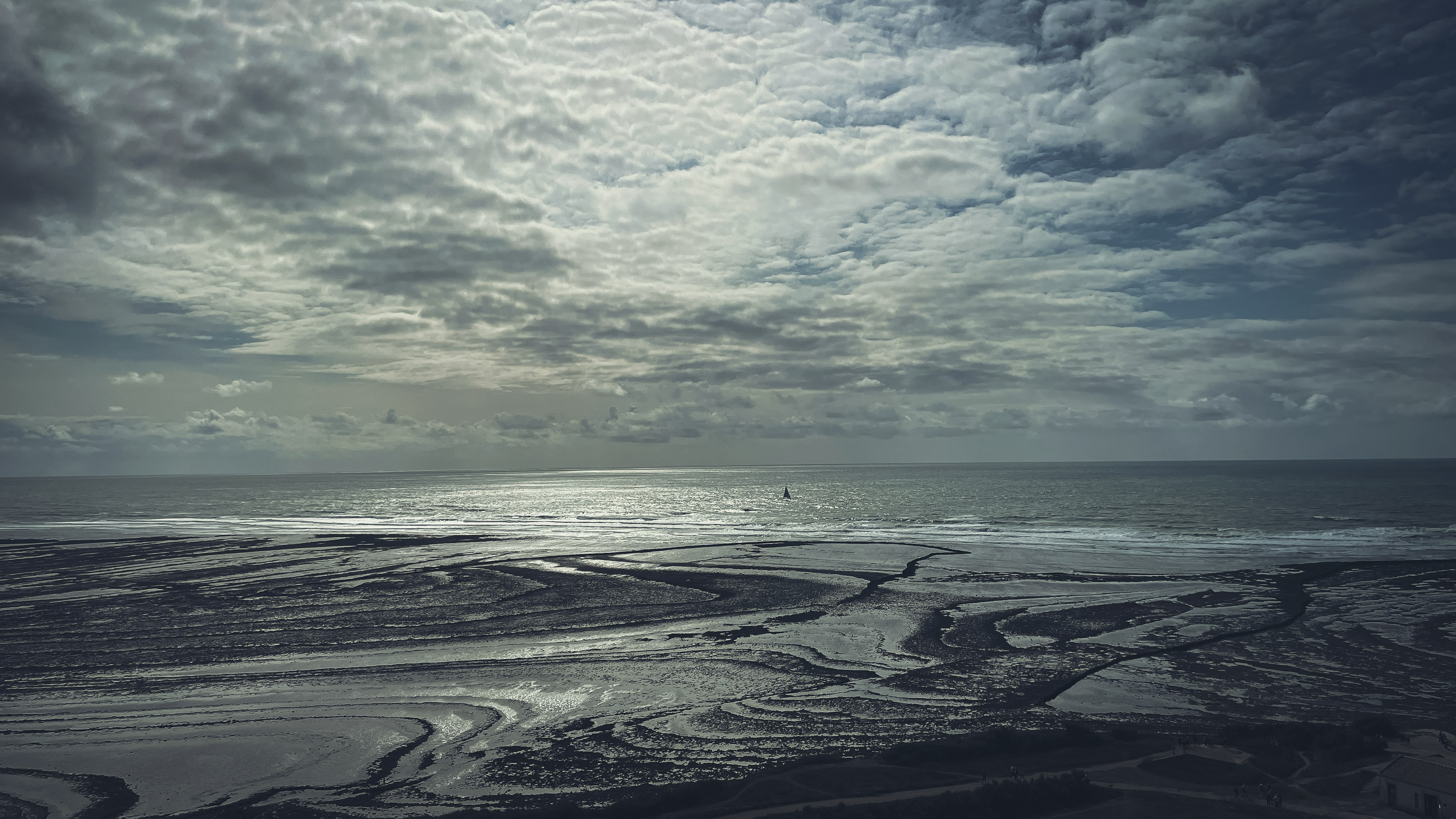 Dramatic cloudy sky over a calm ocean beach.