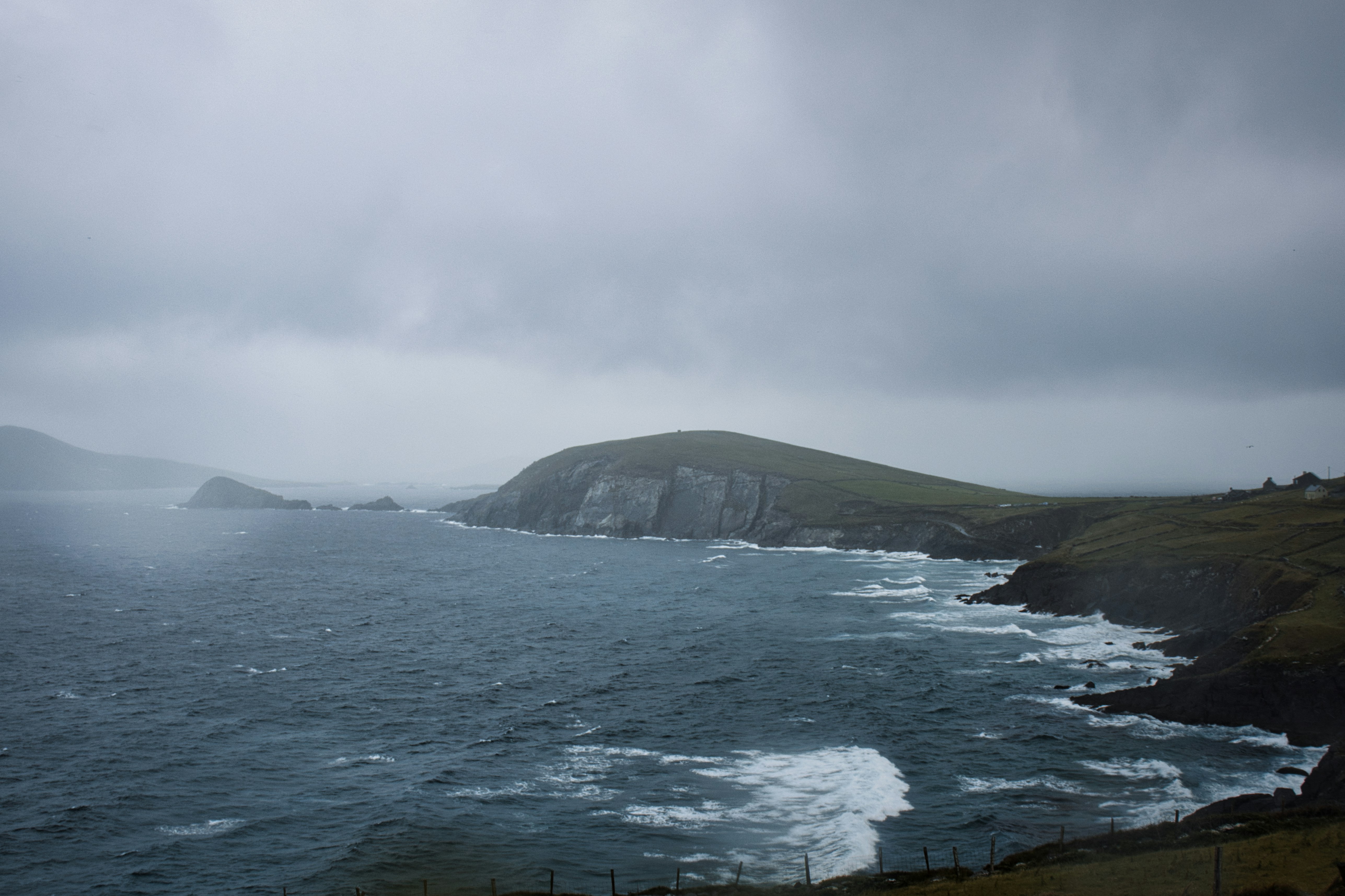 Stormy ocean waves crash against rocky irish coastline.