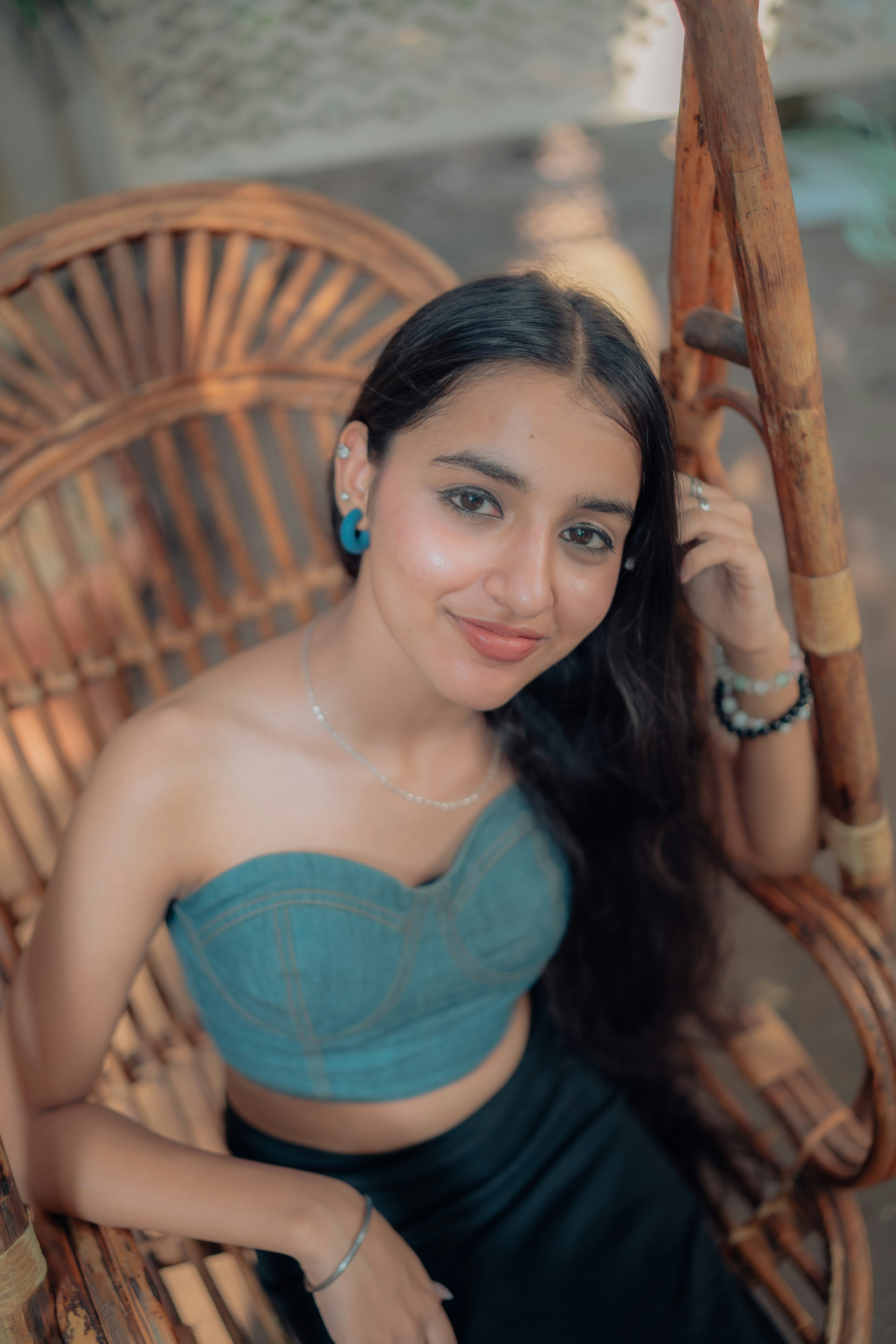Young woman sitting on a wooden swing chair