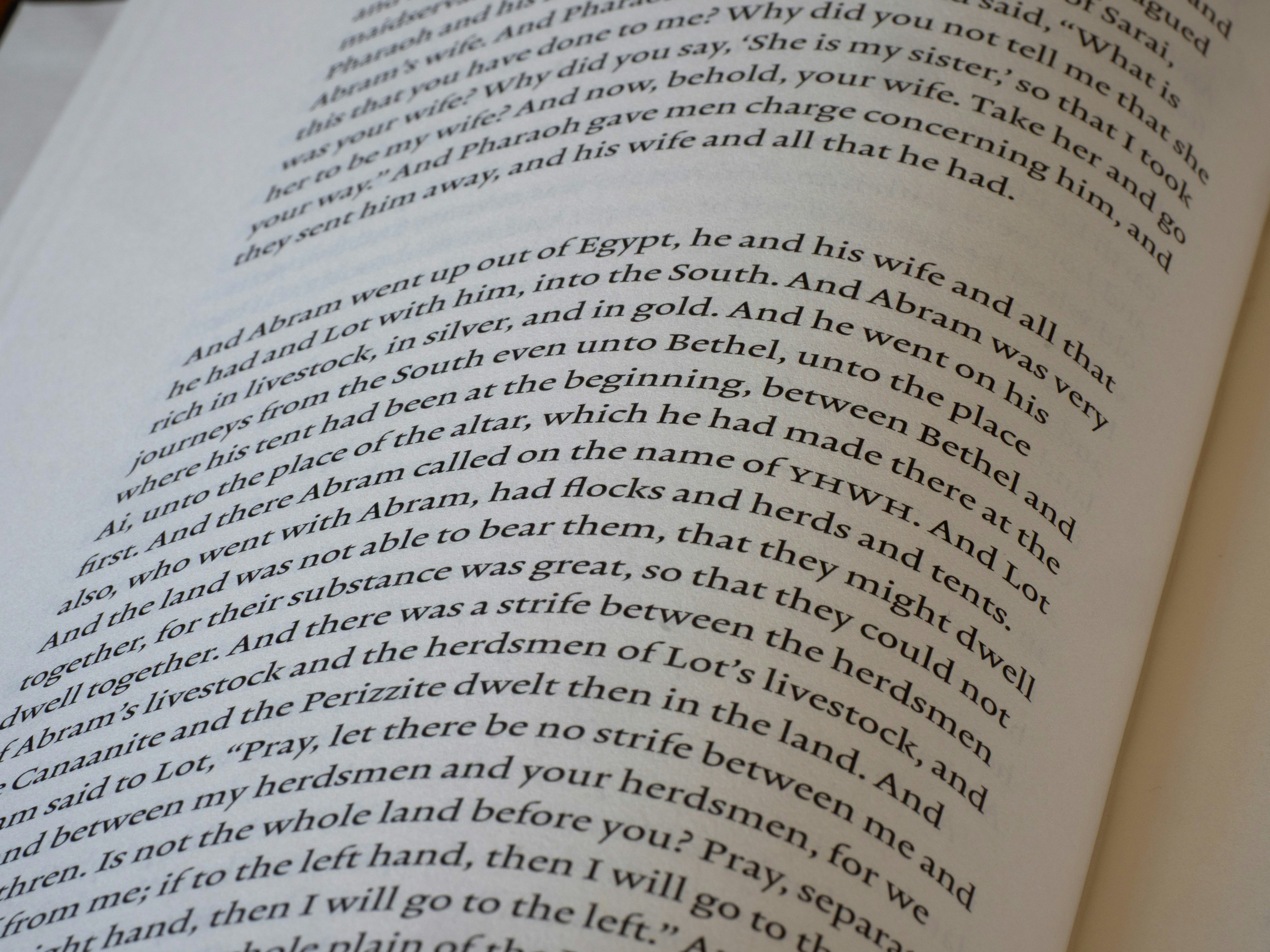 Open book displaying detailed text with a focus on a biblical passage, showcasing the intricacies of written language.
