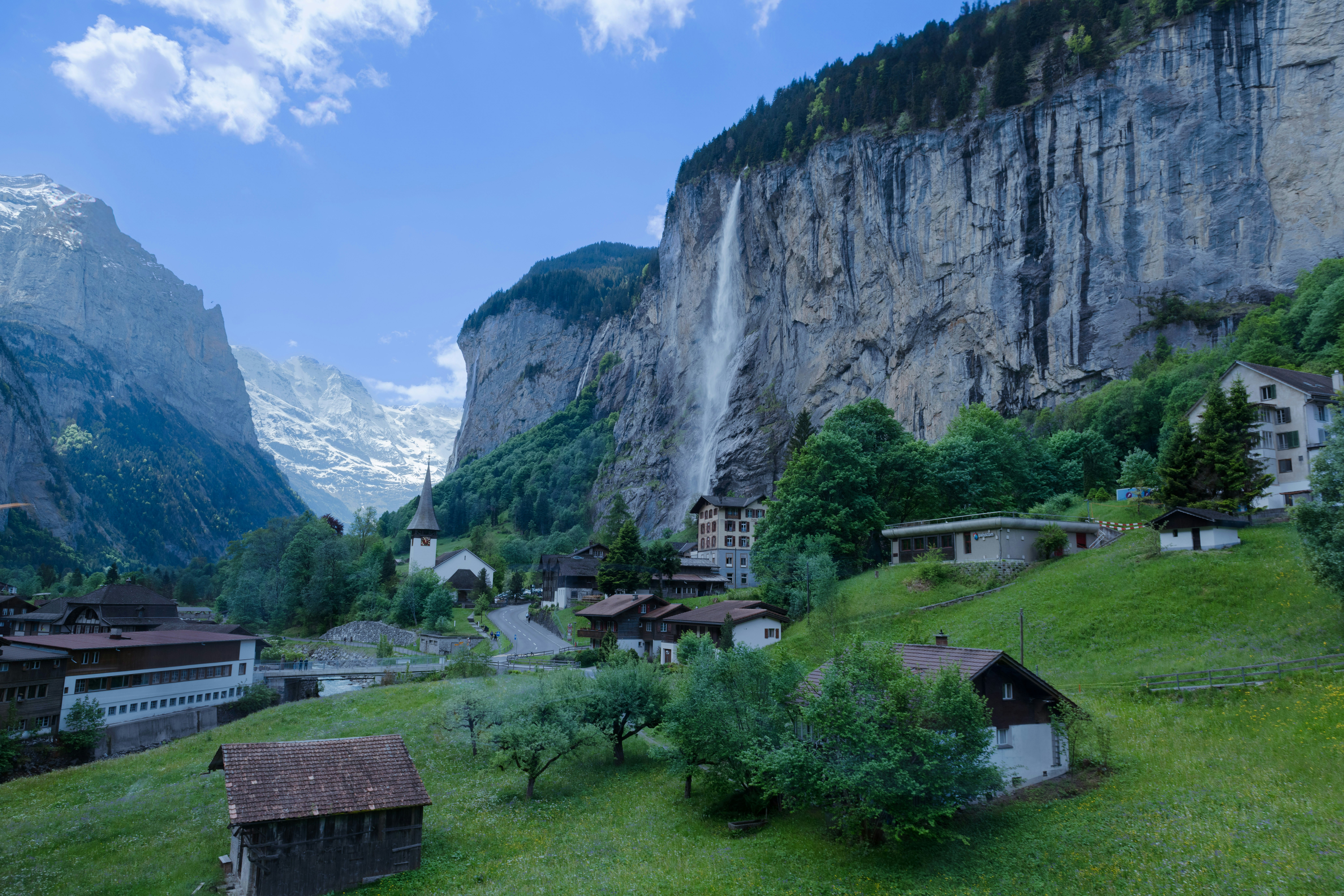 Waterfall cascading down a cliff near a village.