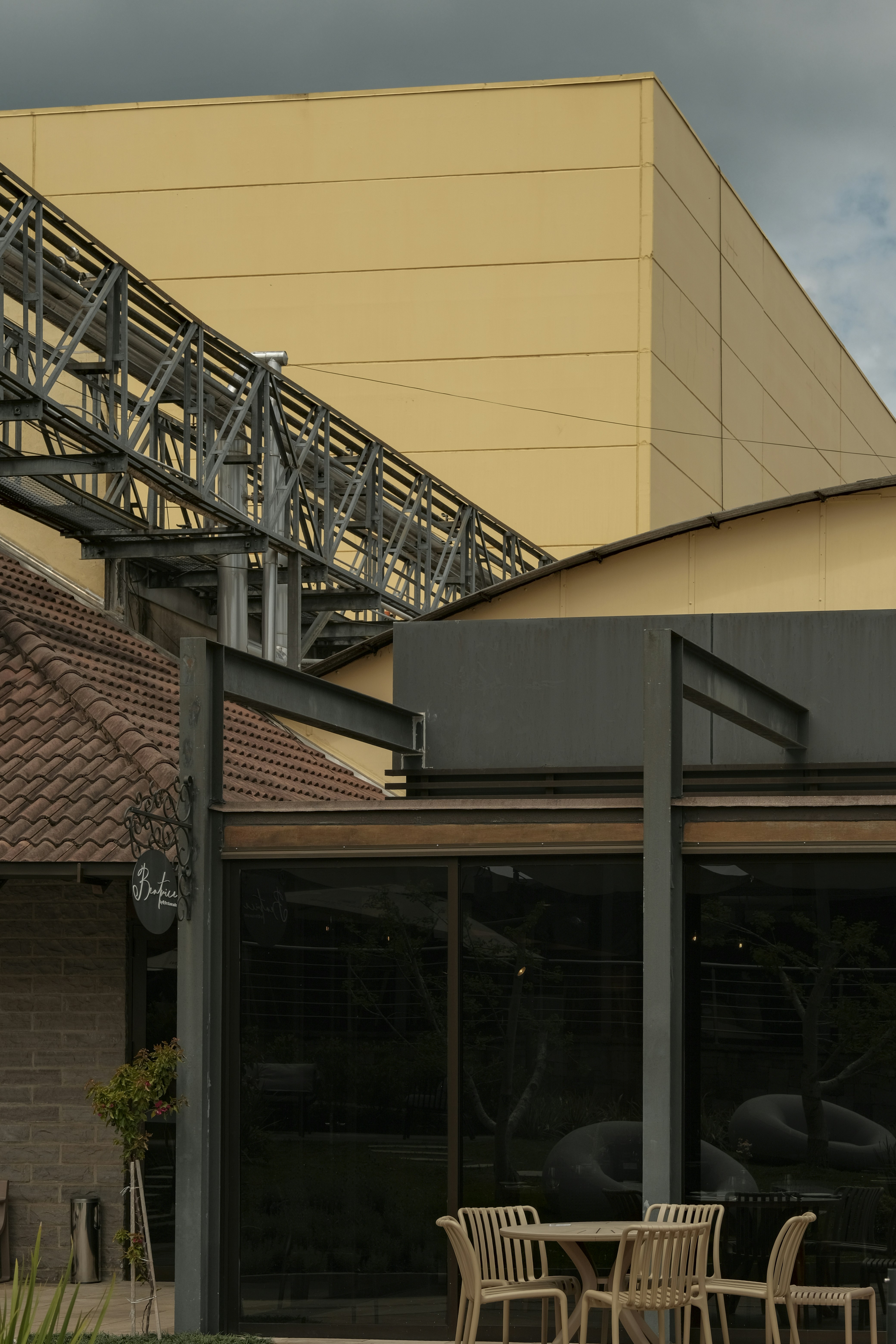 Vinícola Perini, Farroupilha. | Modern industrial buildings with yellow facade and metal structure.