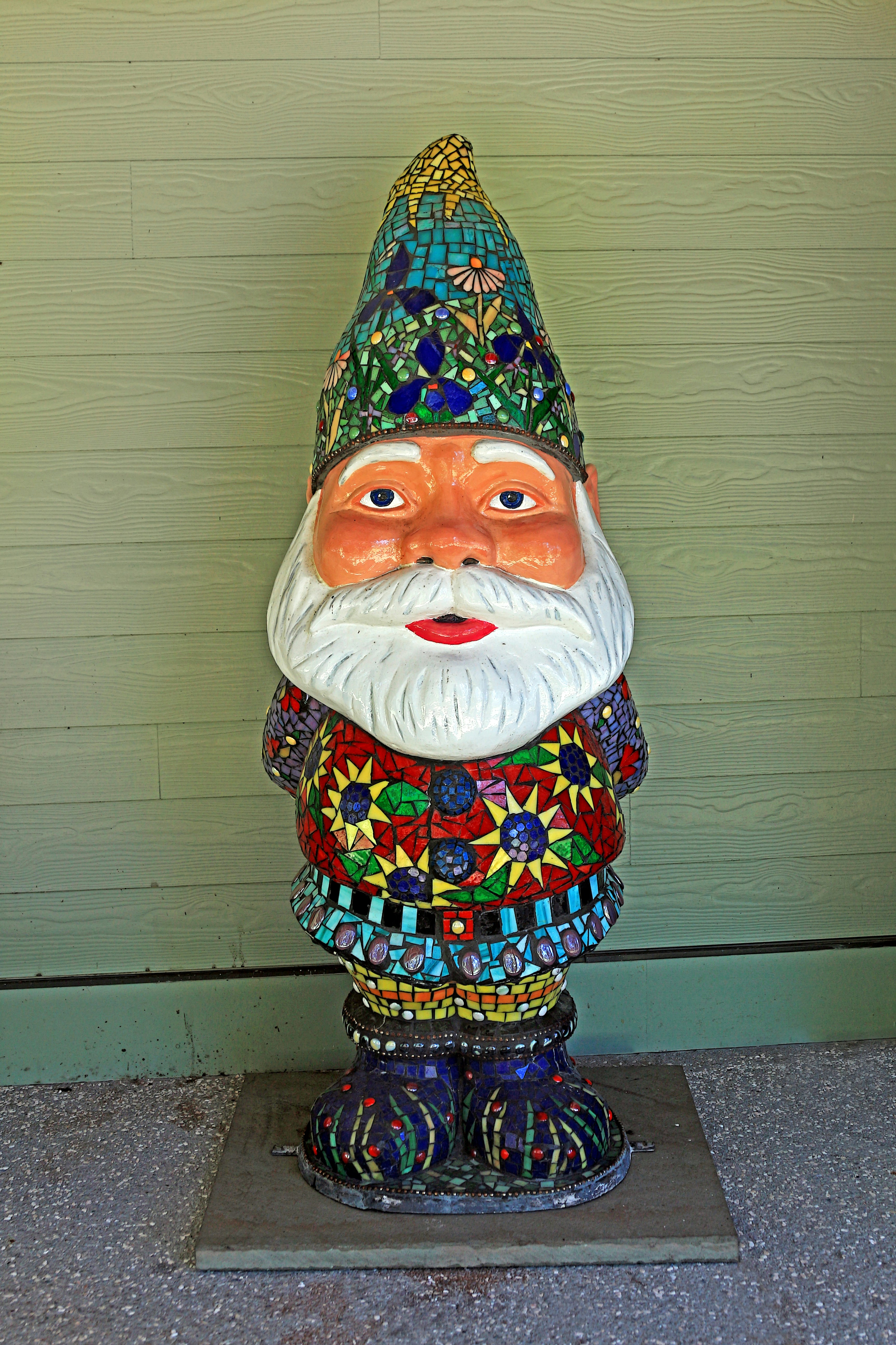 A white-bearded gnome statue. | Mosaic garden gnome with colorful tiled hat and clothing