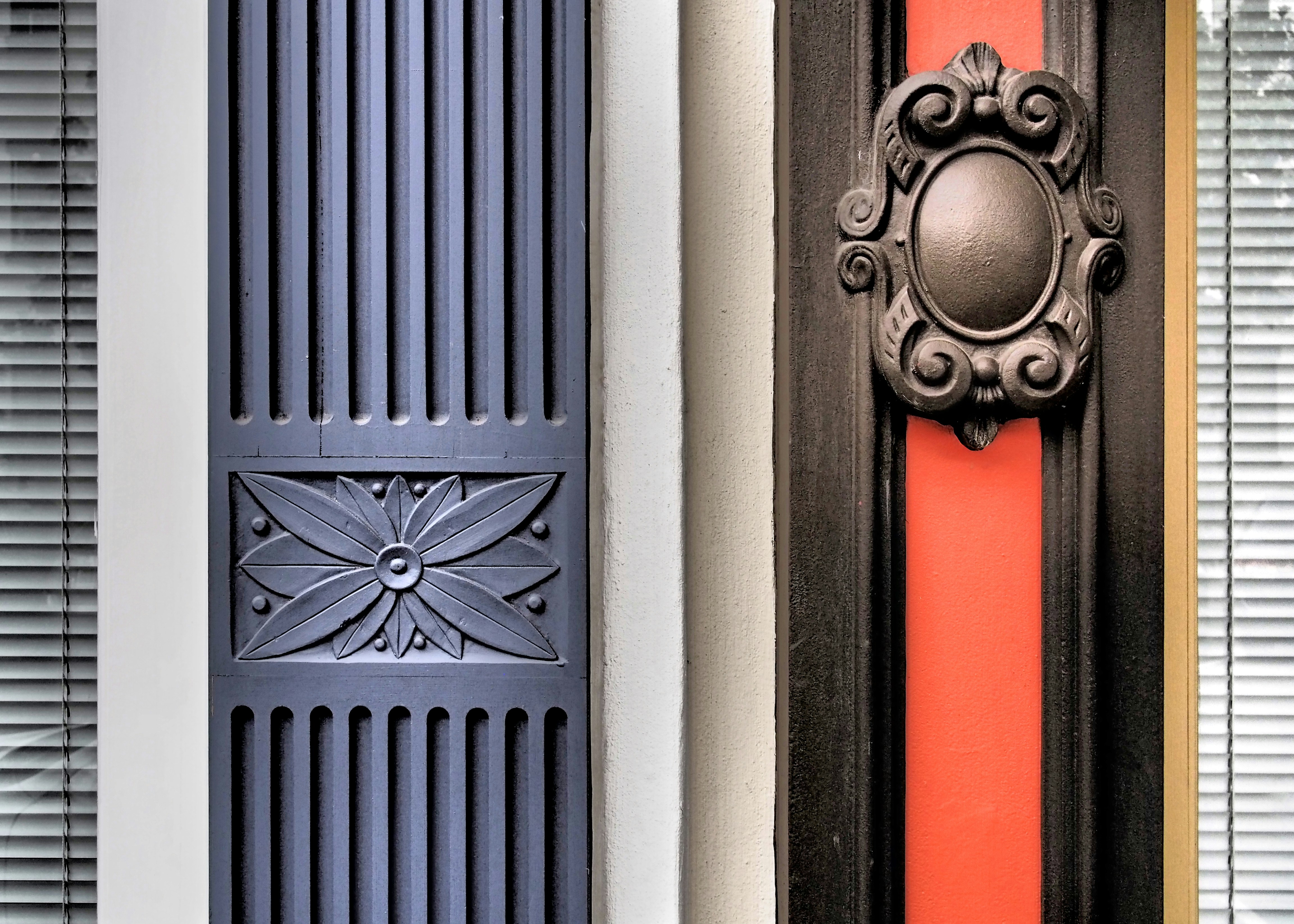 Neighboring offices and their different window trims. | Close-up of ornate architectural details on building facade.