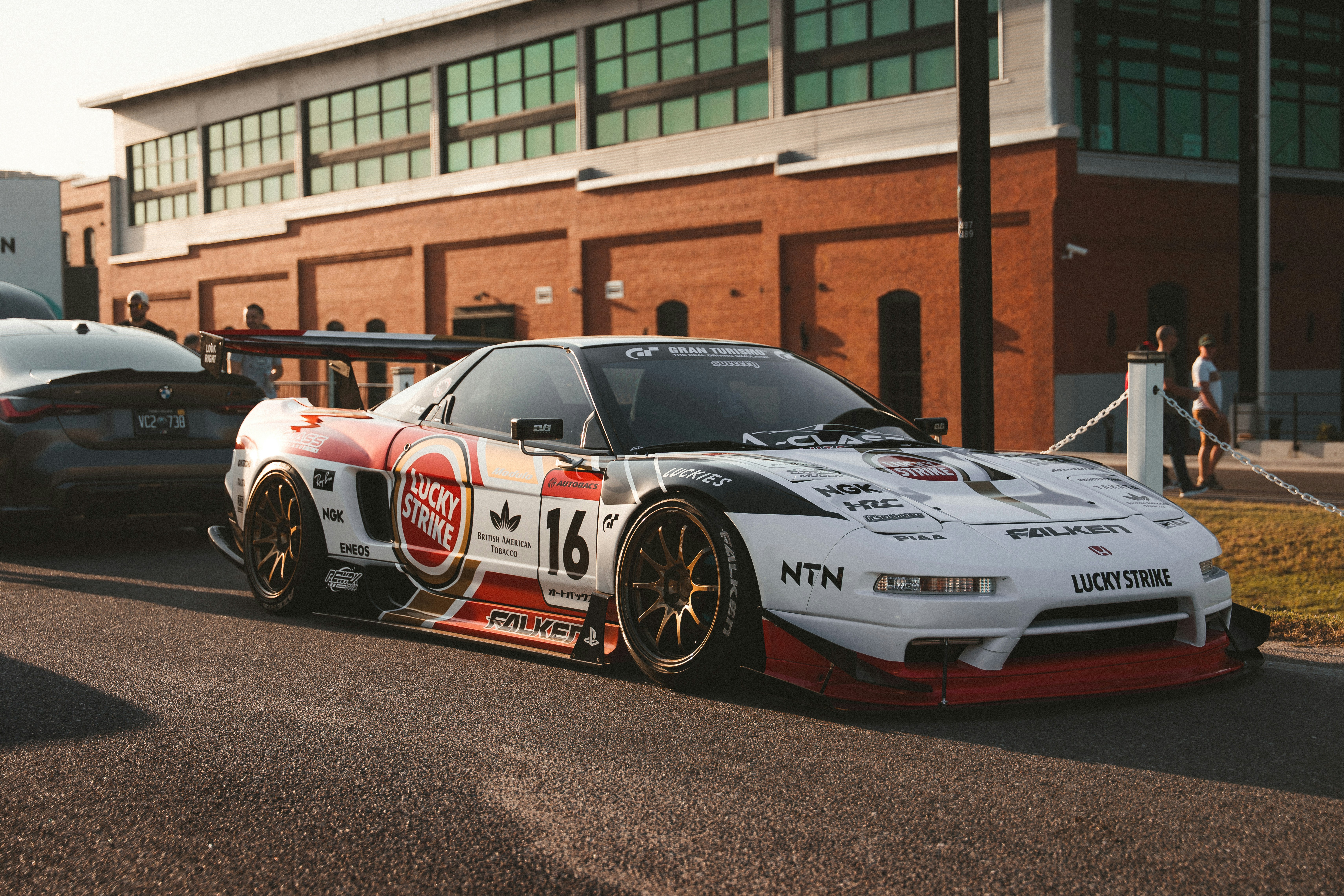 A white race car with sponsor decals parked outside. photo – Free ...
