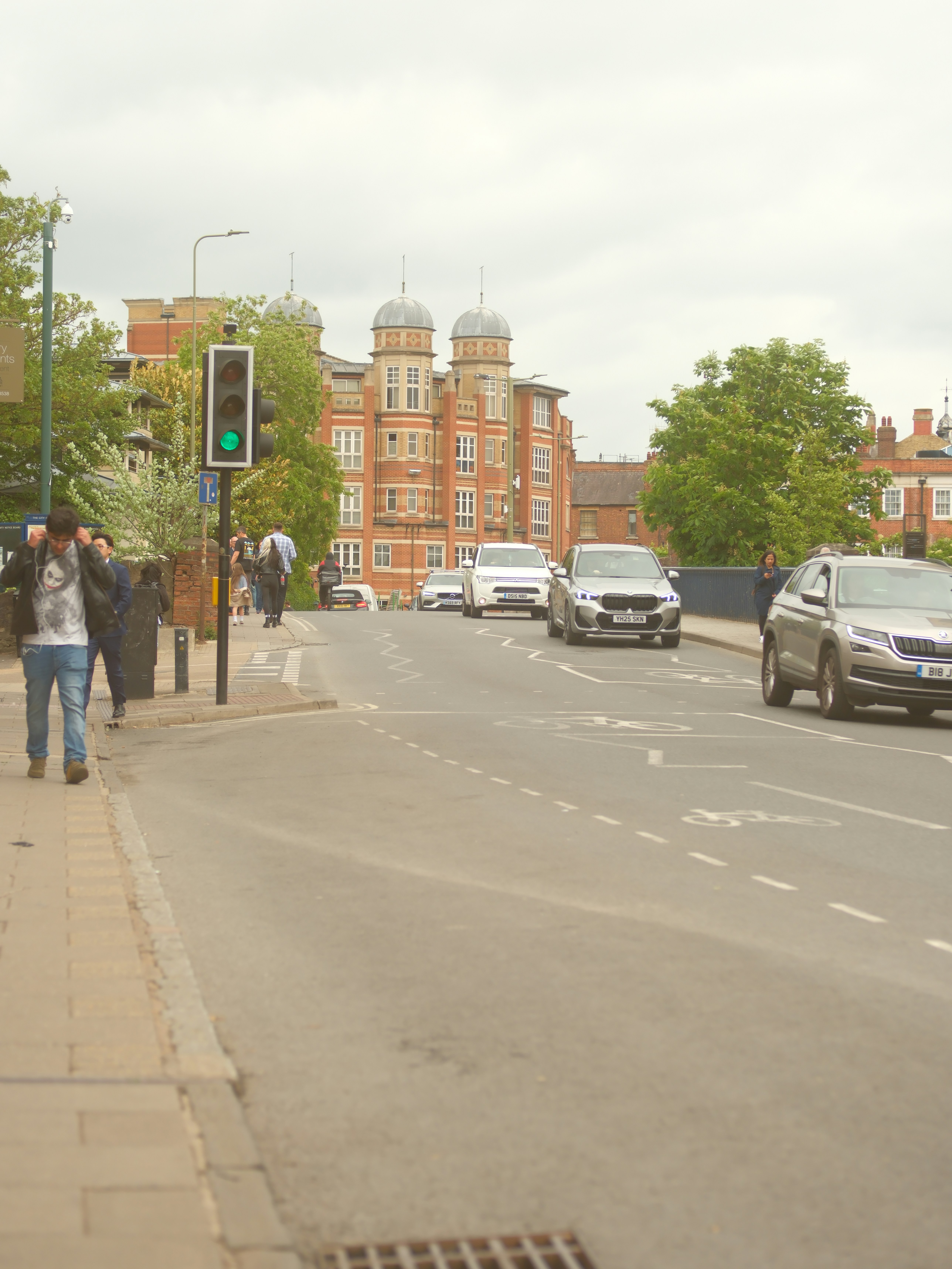 Cars driving on a street with buildings and trees.