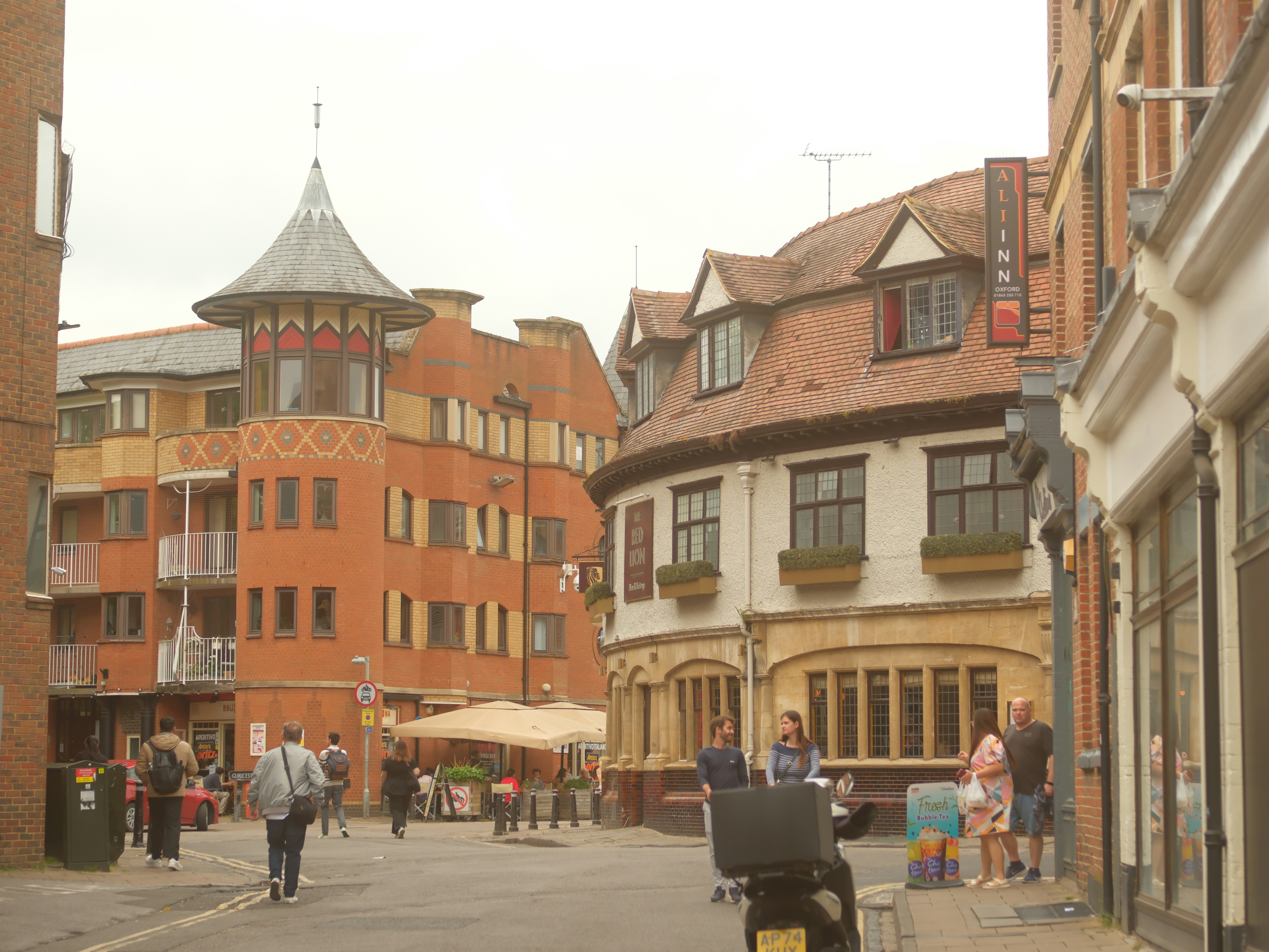 Charming street scene showcasing a mix of modern and traditional buildings, with pedestrians enjoying the vibrant atmosphere.