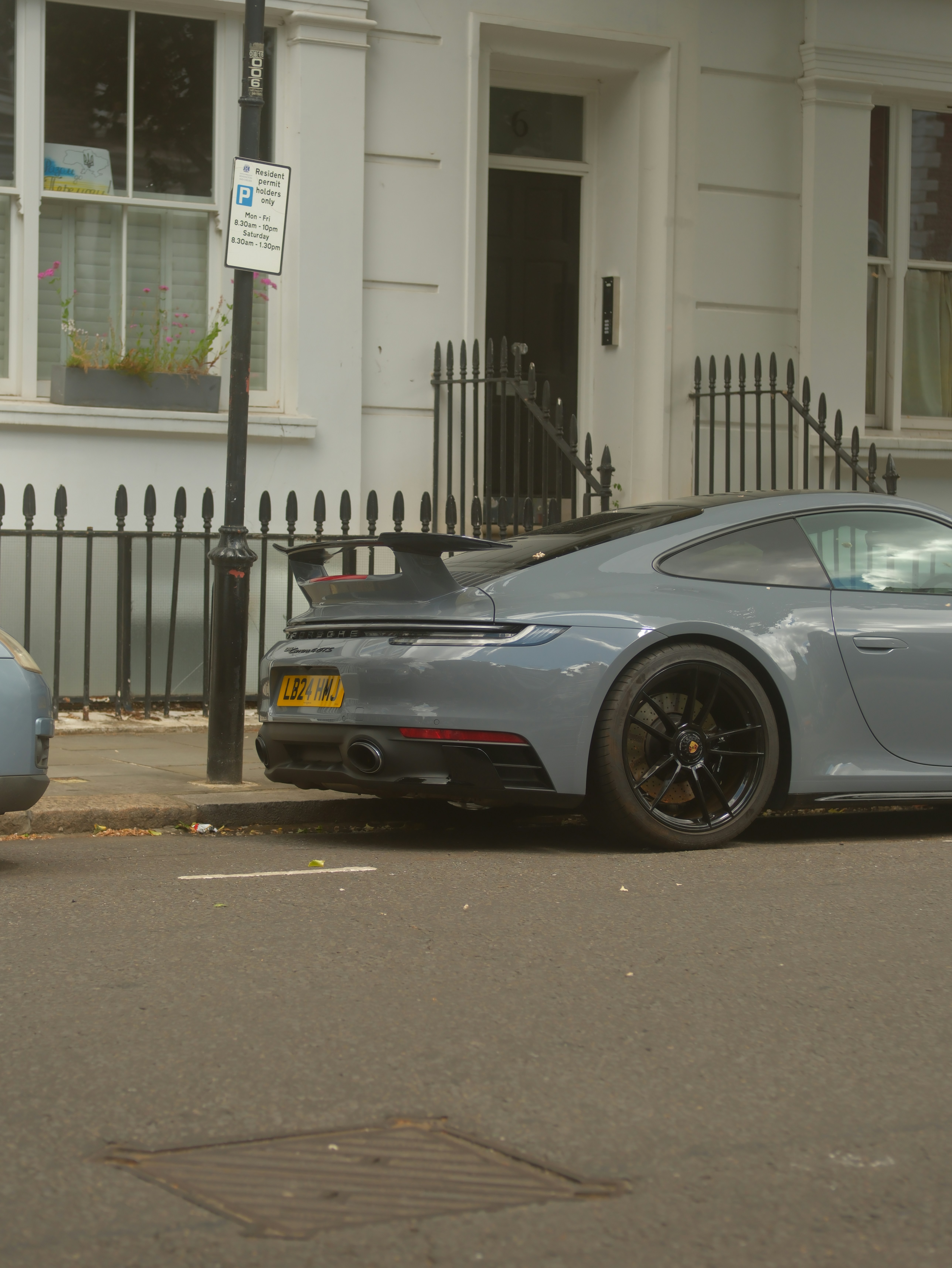 Grey porsche parked on a london street.