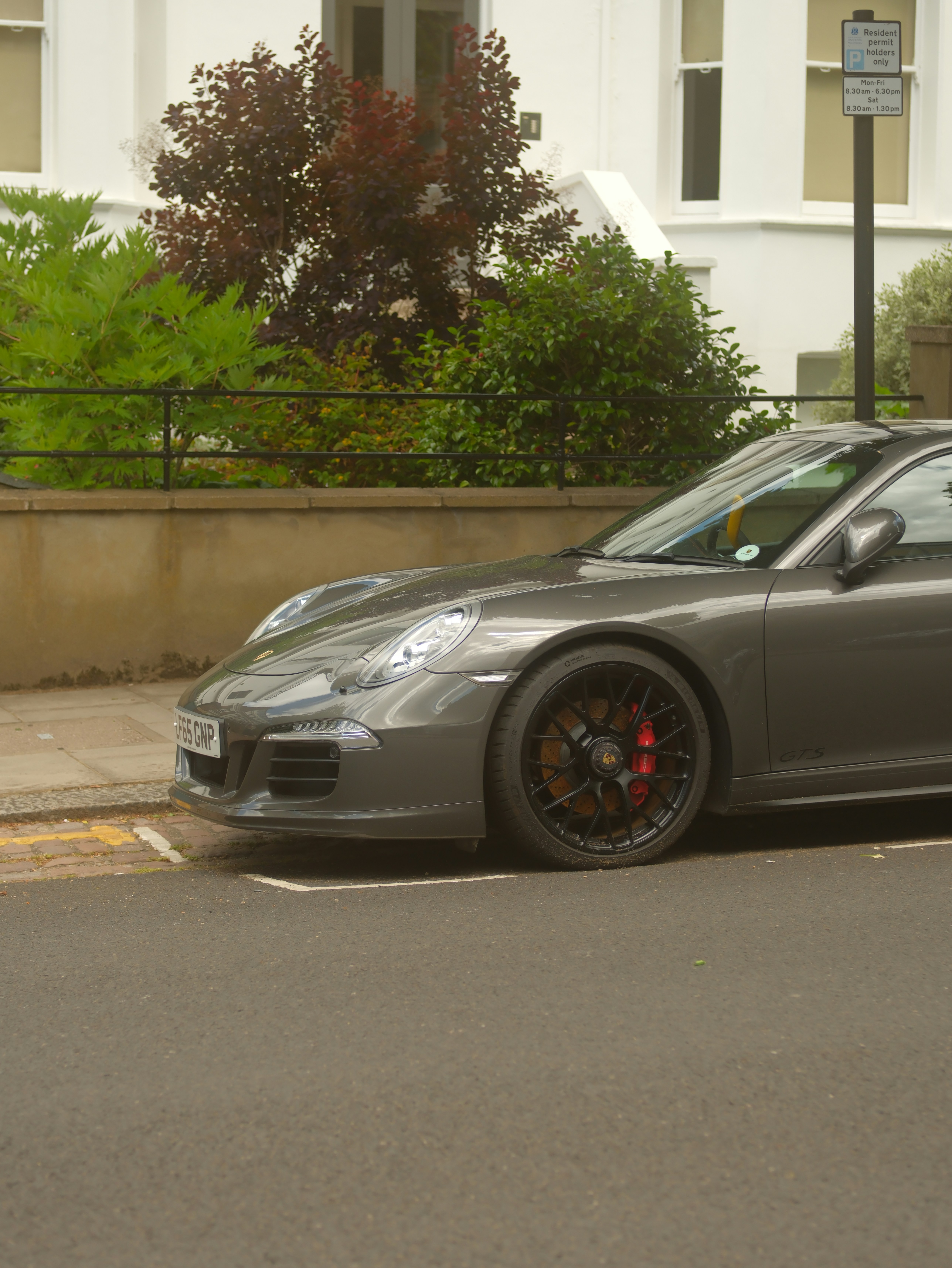A grey porsche parked on a street.